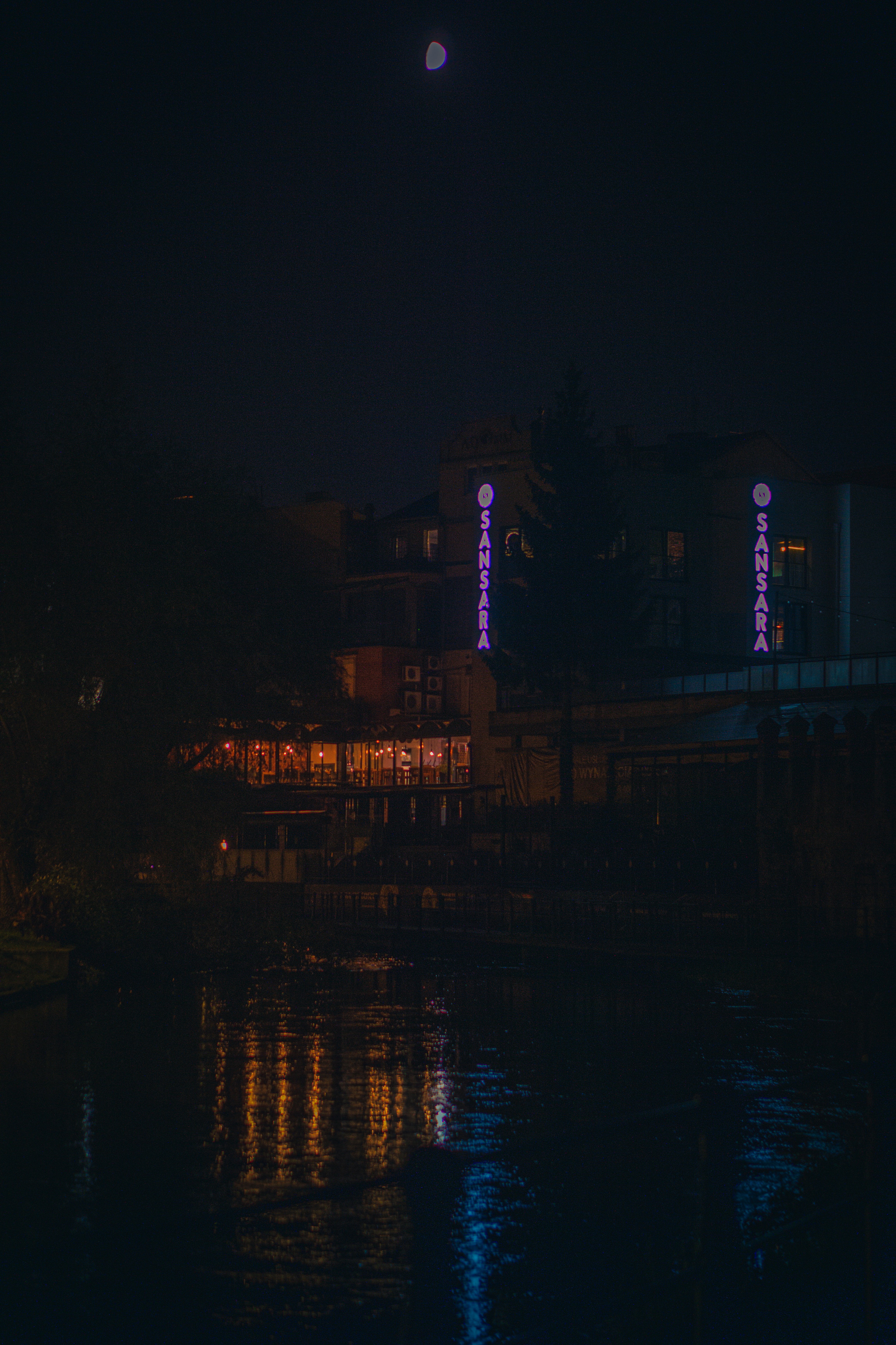 Un bâtiment éclairé la nuit avec une pleine lune en arrière-plan photo ...