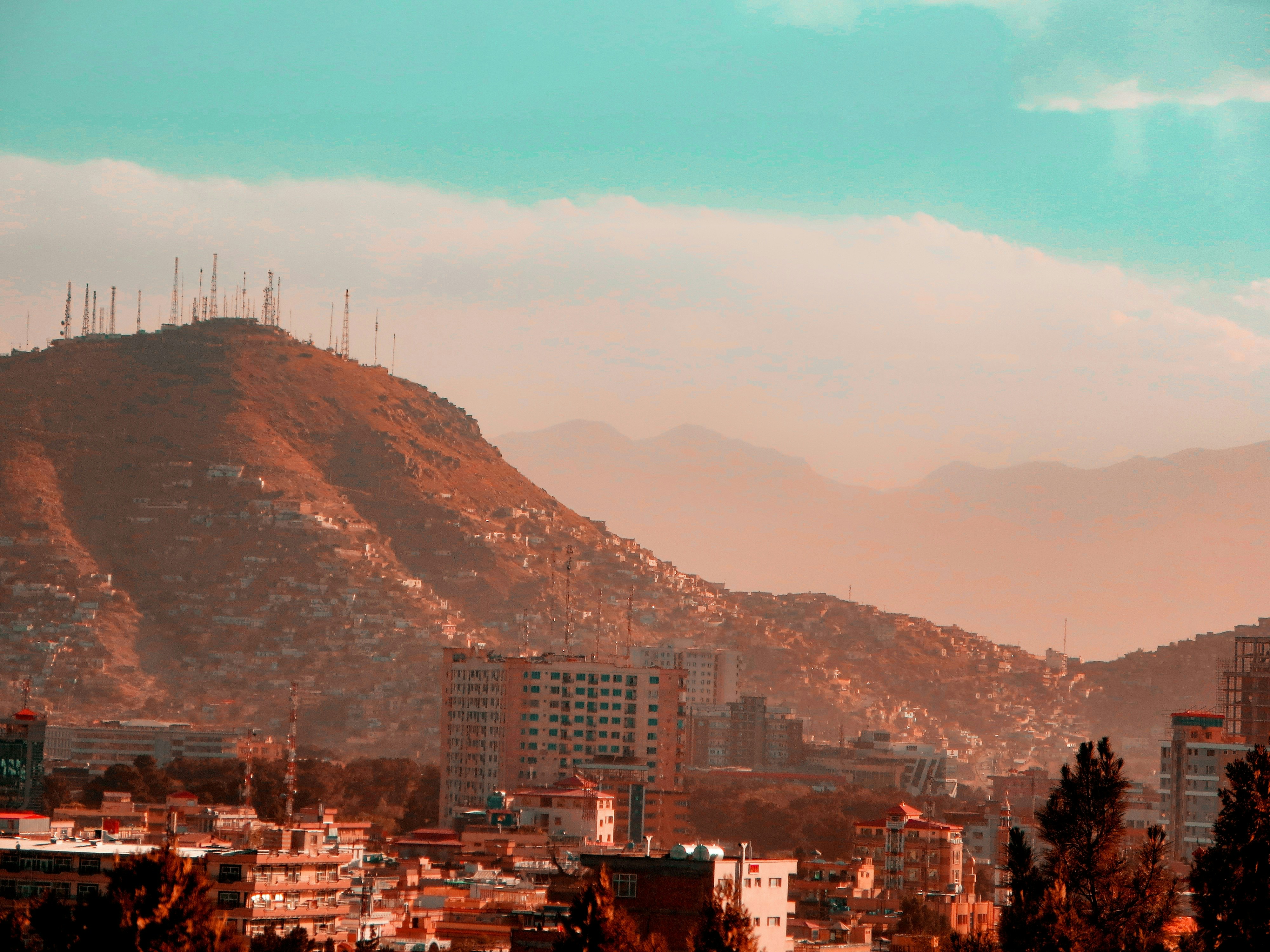 A view of a city with mountains in the background photo – Free Kabul ...