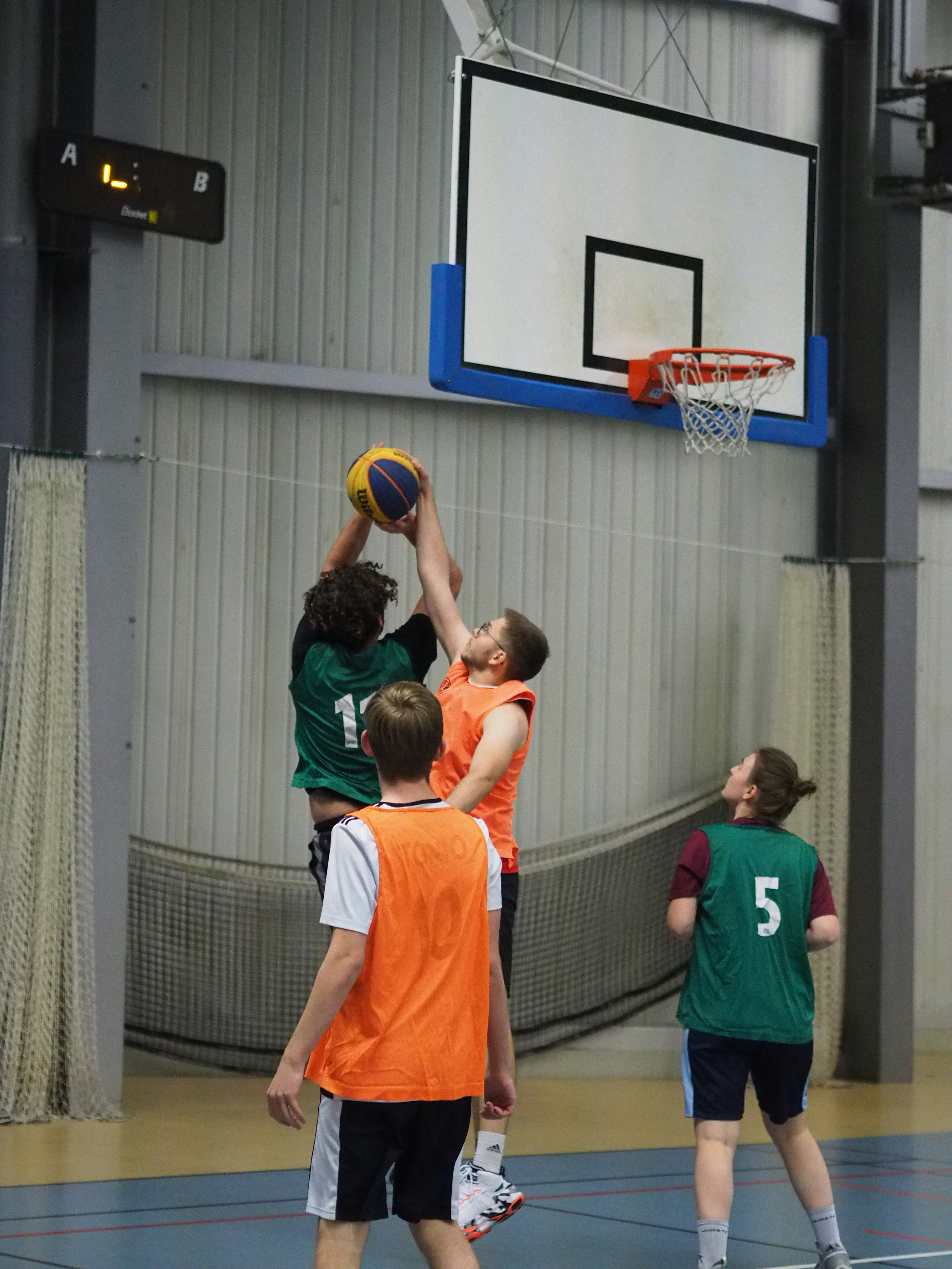 A group of young men playing a game of basketball photo – Free ...