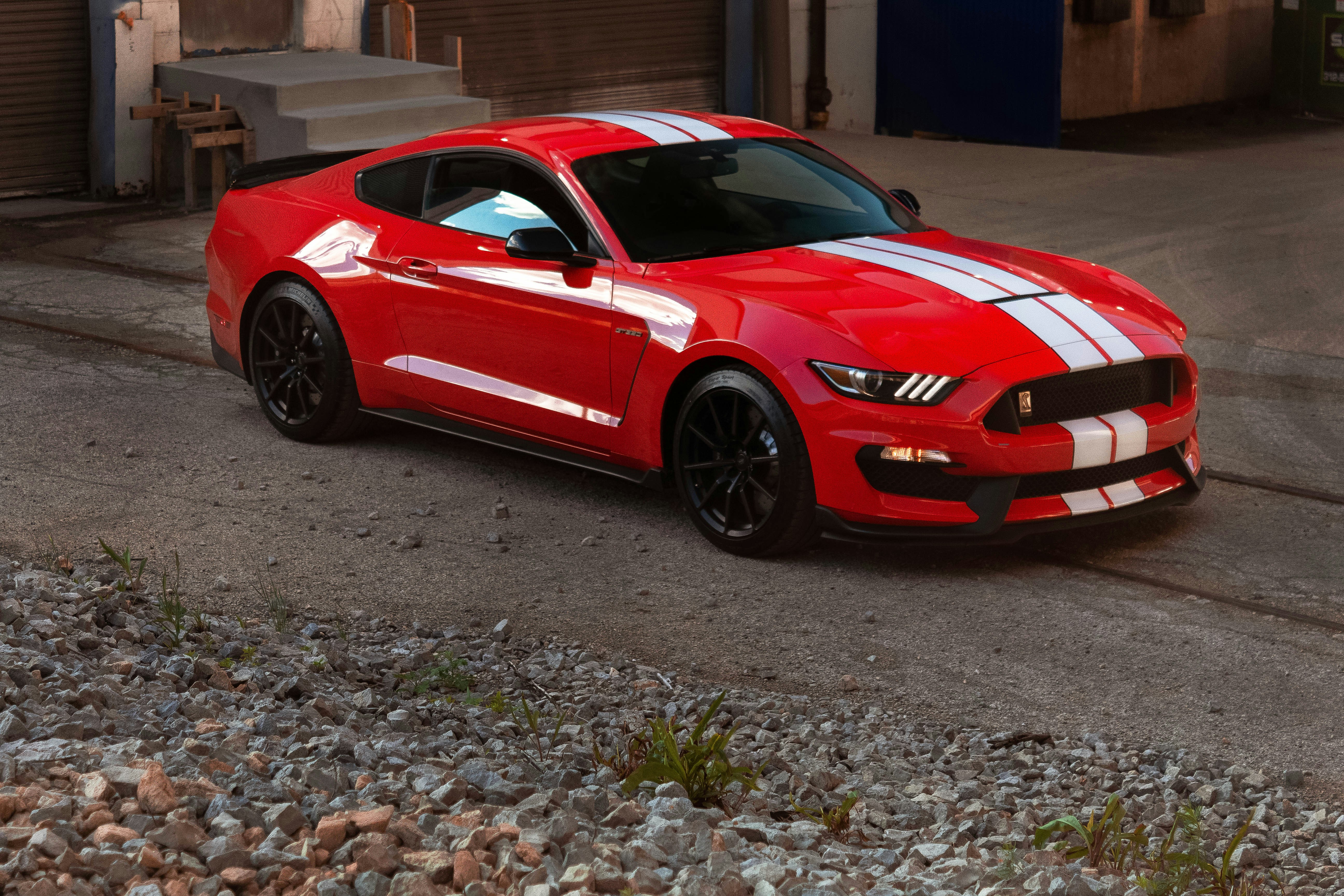 Foto zum Thema Ein roter Mustang, der am Straßenrand geparkt ist ...