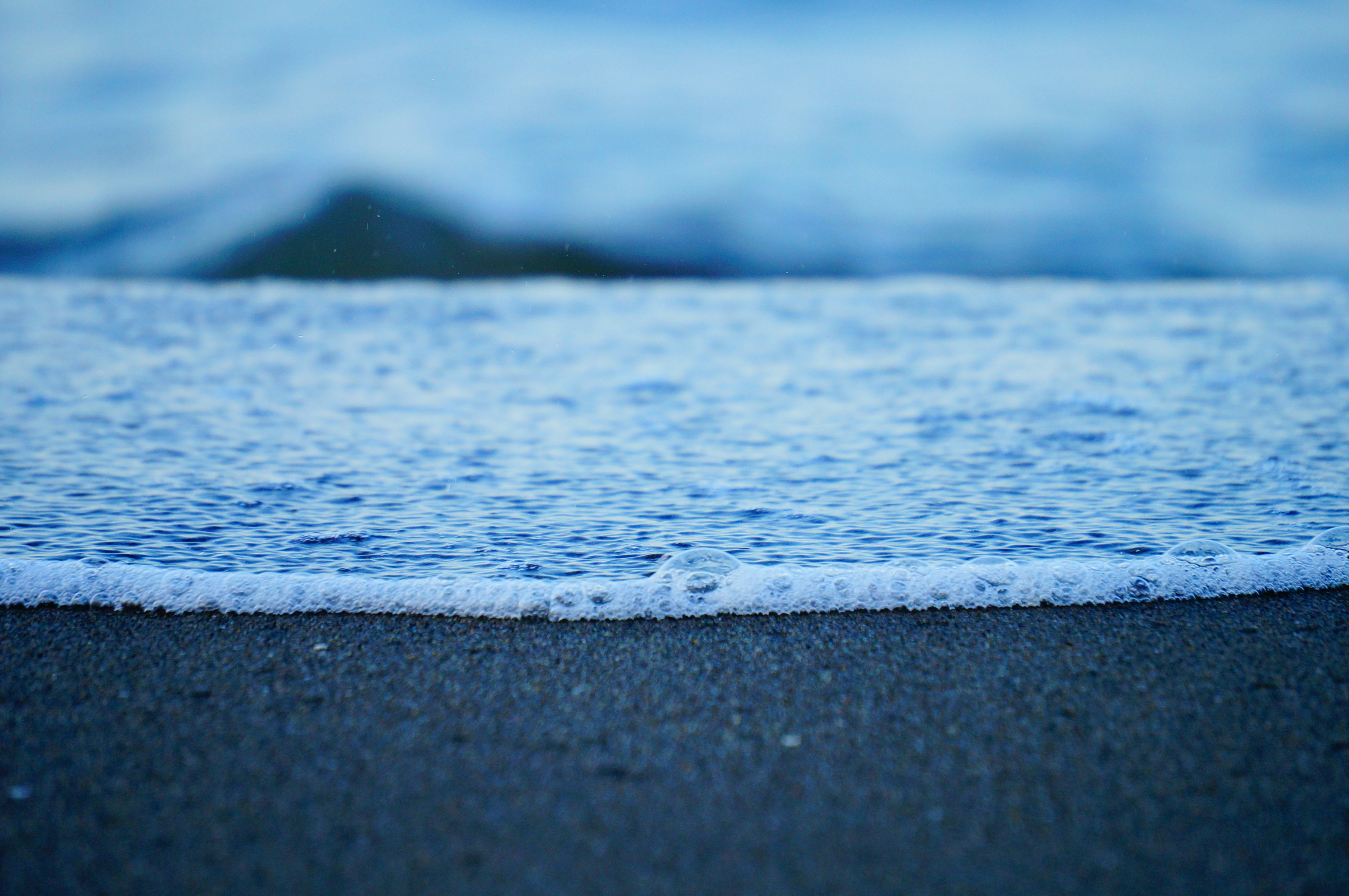 Blue Edge: Foam Lacing the Dark Sand at a Quiet Shore