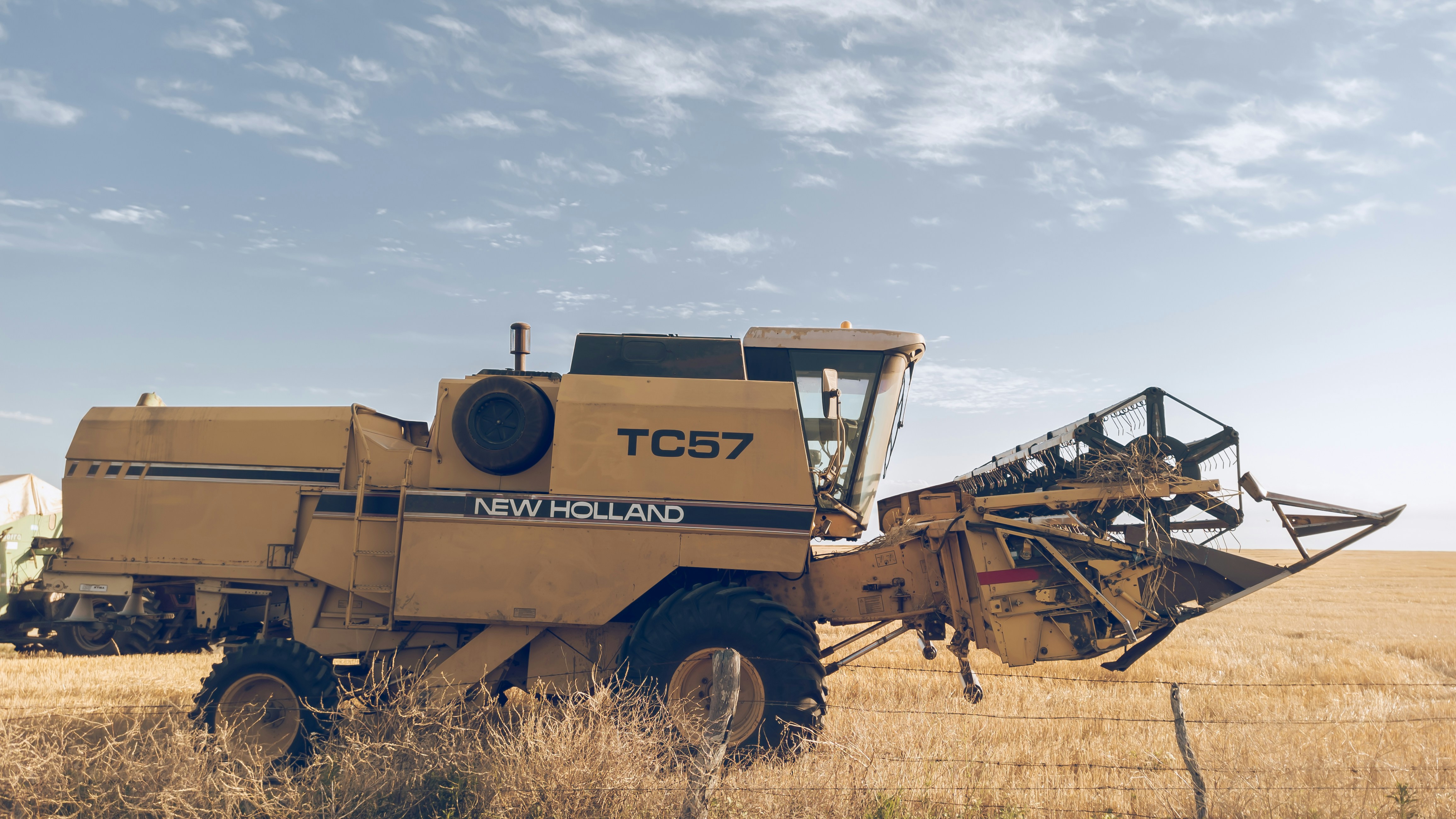 Dusty Harvest: The Old New Holland TC57 in a Quiet Prairie Sunset