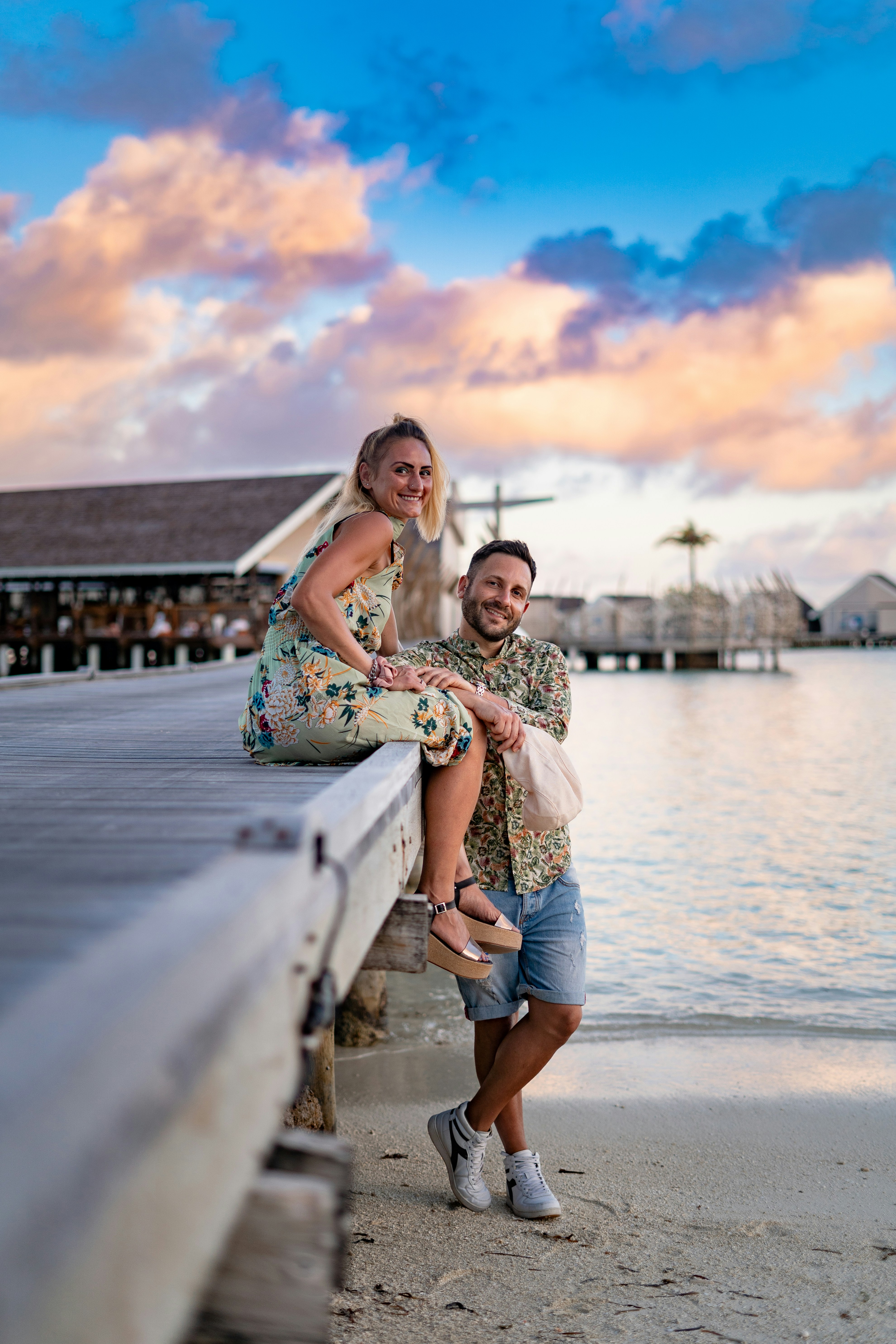 Pastel Sunset, Pierside Joy: A Couple's Moment on the Waterfront