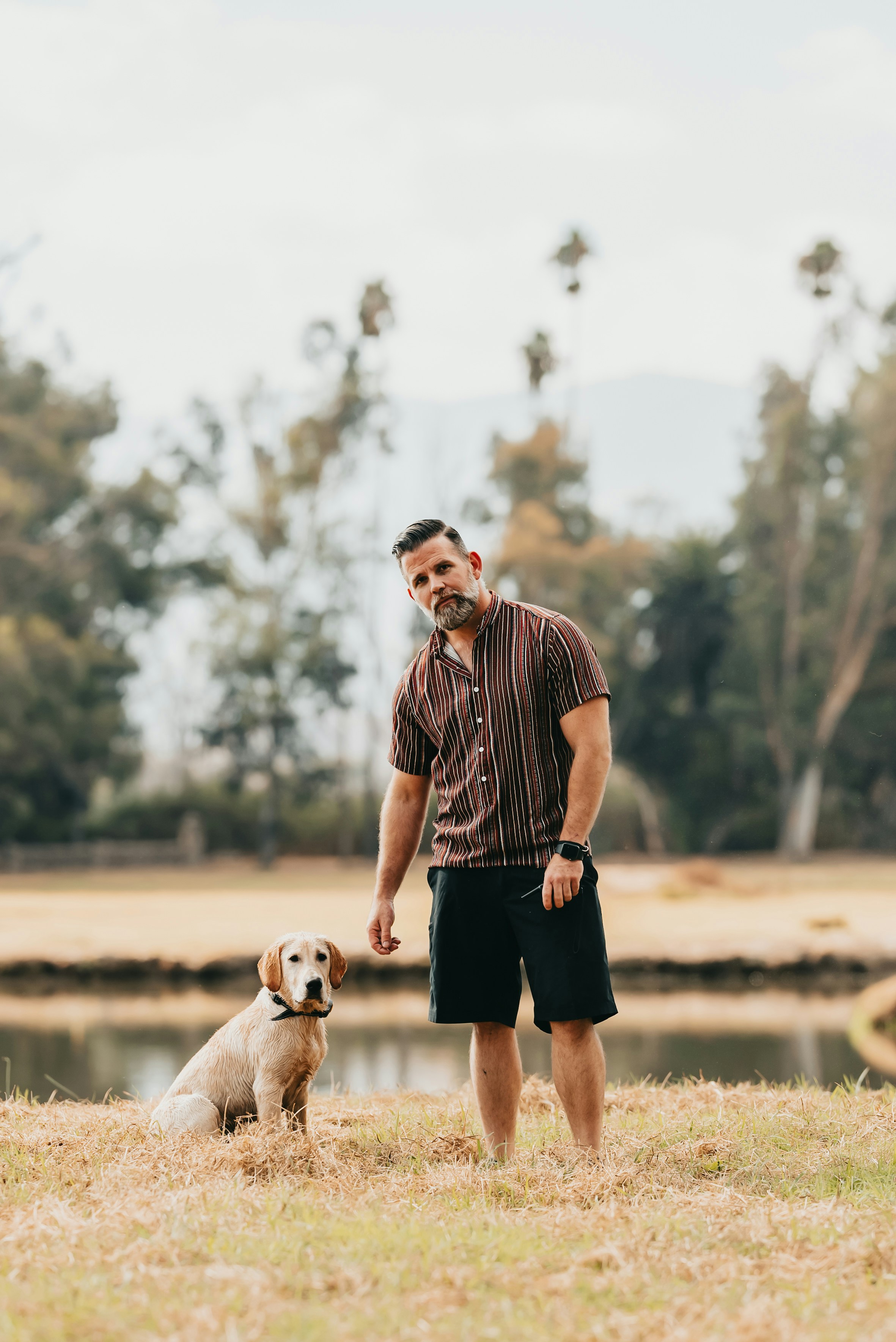 Man and Dog in a Quiet Riverside Clearing