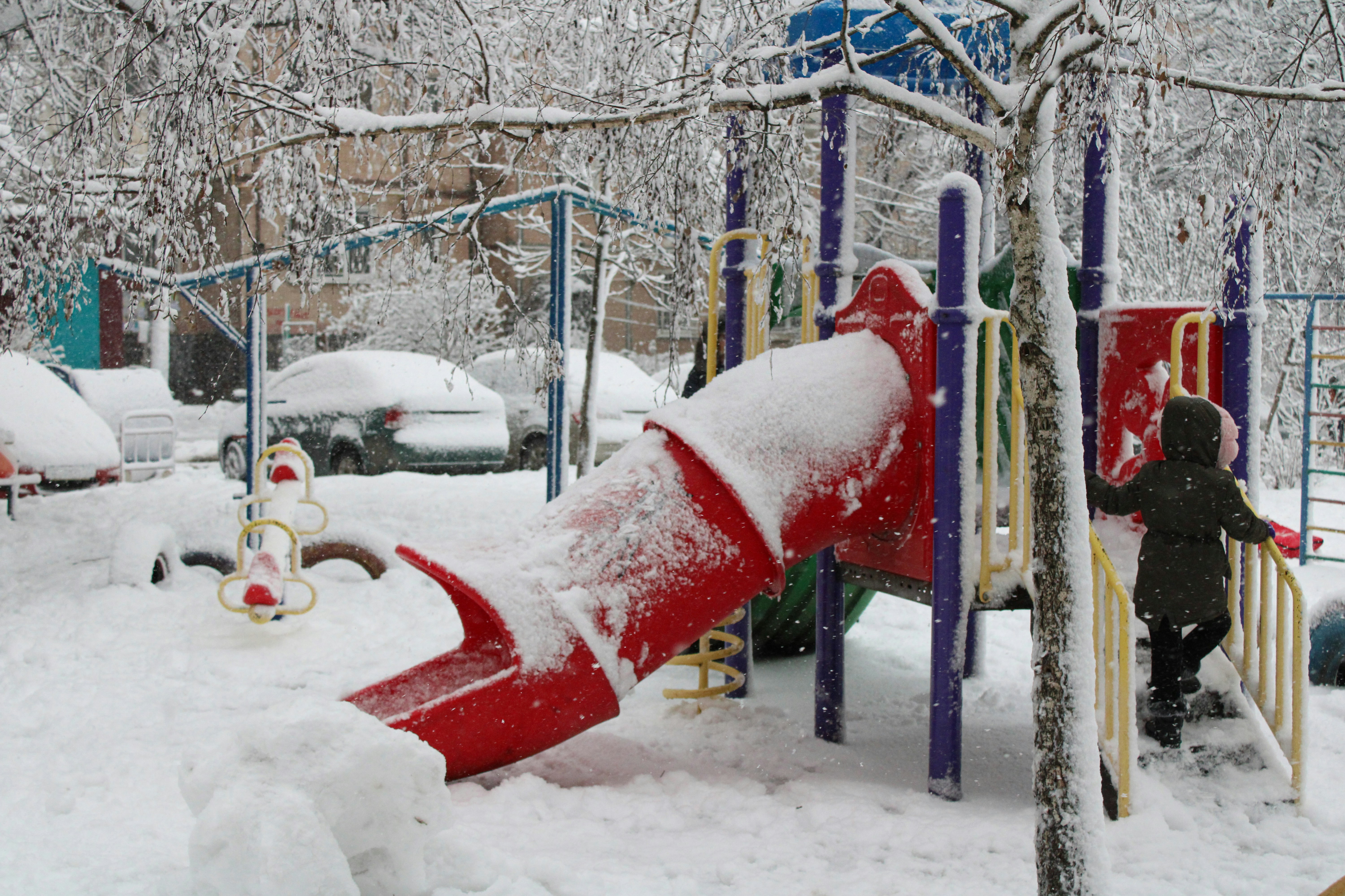 Crimson Slide Buried in White: A Snowy Playground Scene