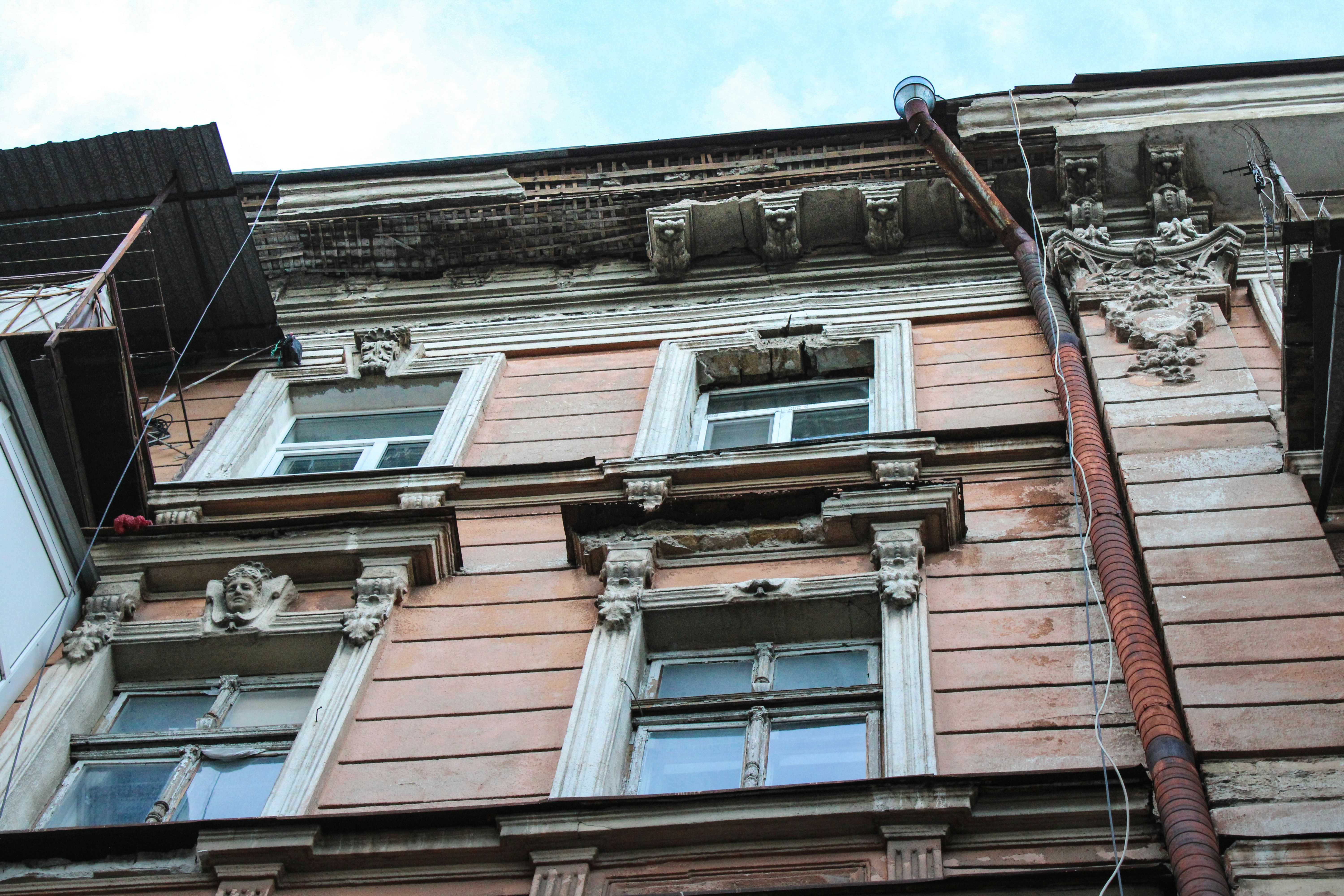 A tall building with lots of windows next to a street photo – Free ...