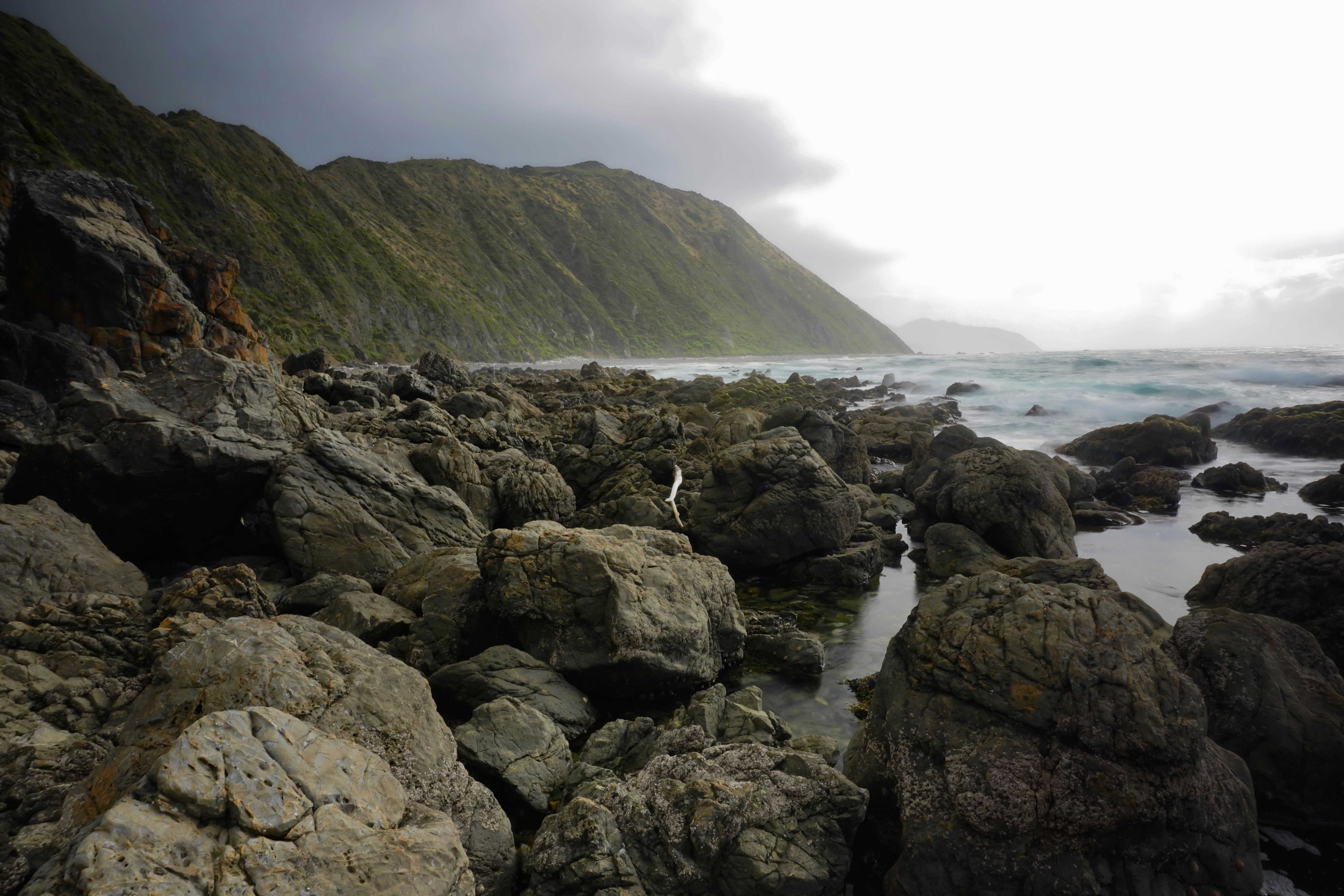 Lone Figure on the Ragged Coast: Mist, Rock, and Sea