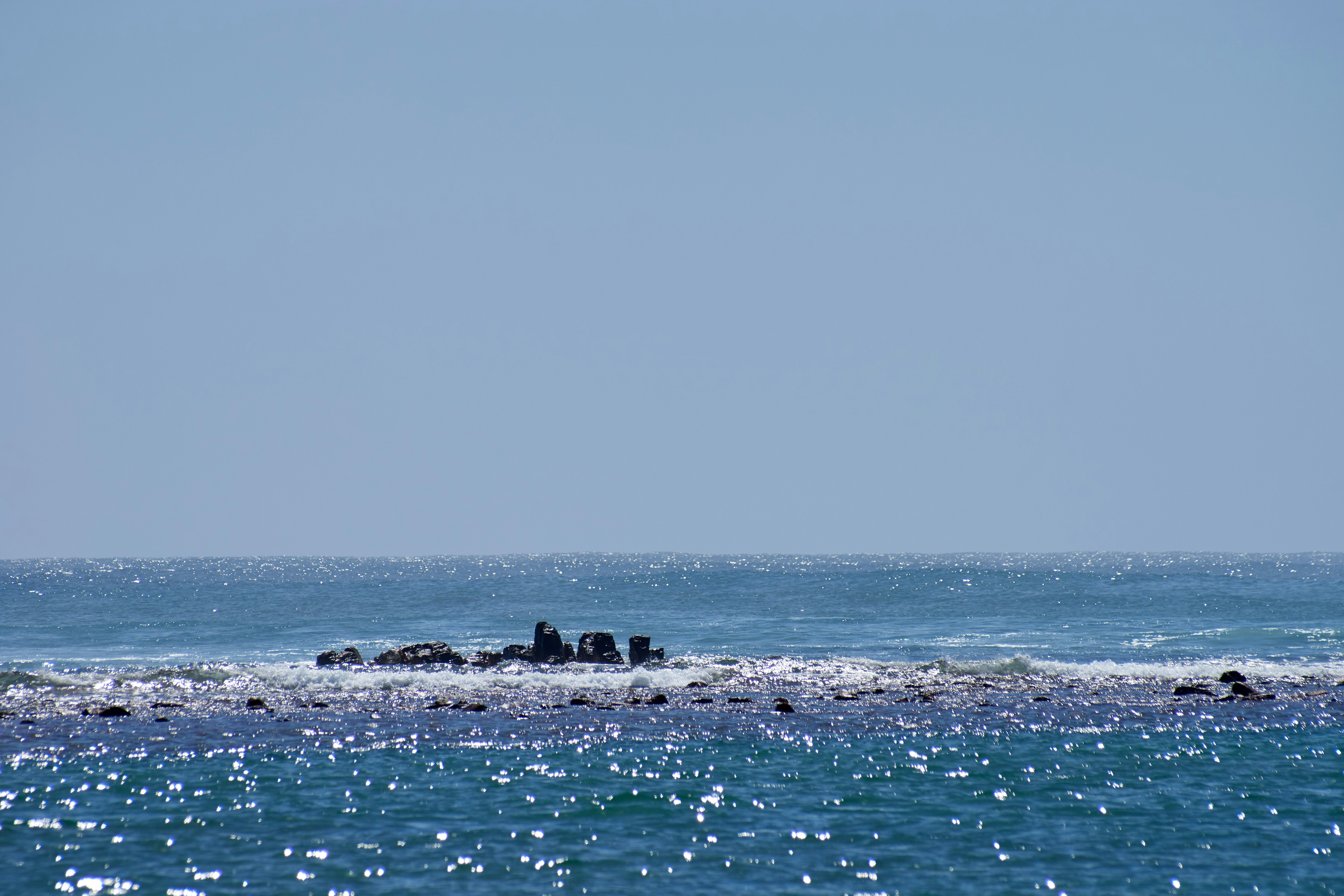 Un groupe de personnes assises au sommet d’un rocher dans l’océan photo ...
