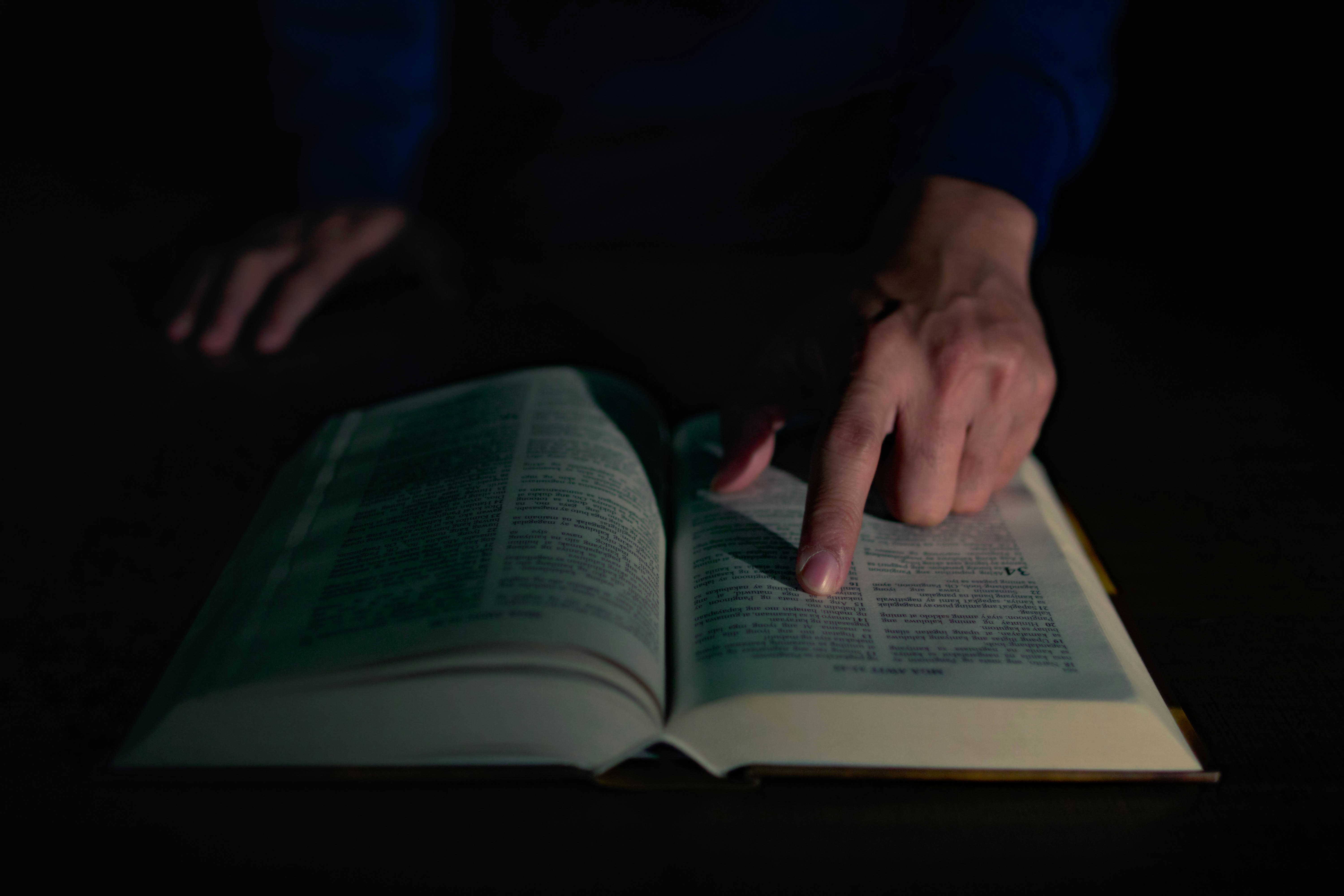 A person touching a book with their finger photo – Free Bible Image on ...