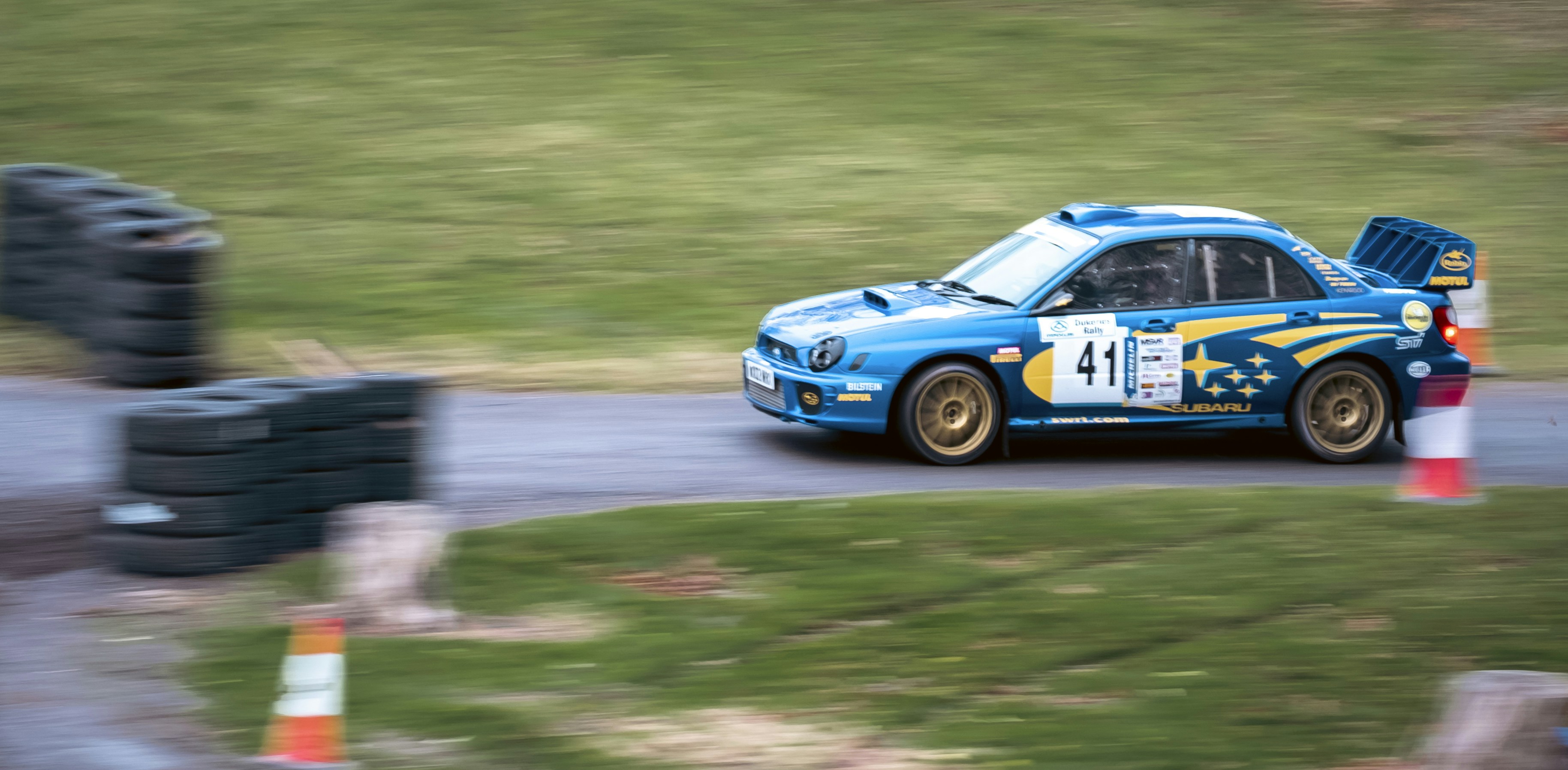 A blue car driving down a race track photo – Free Donington park ...