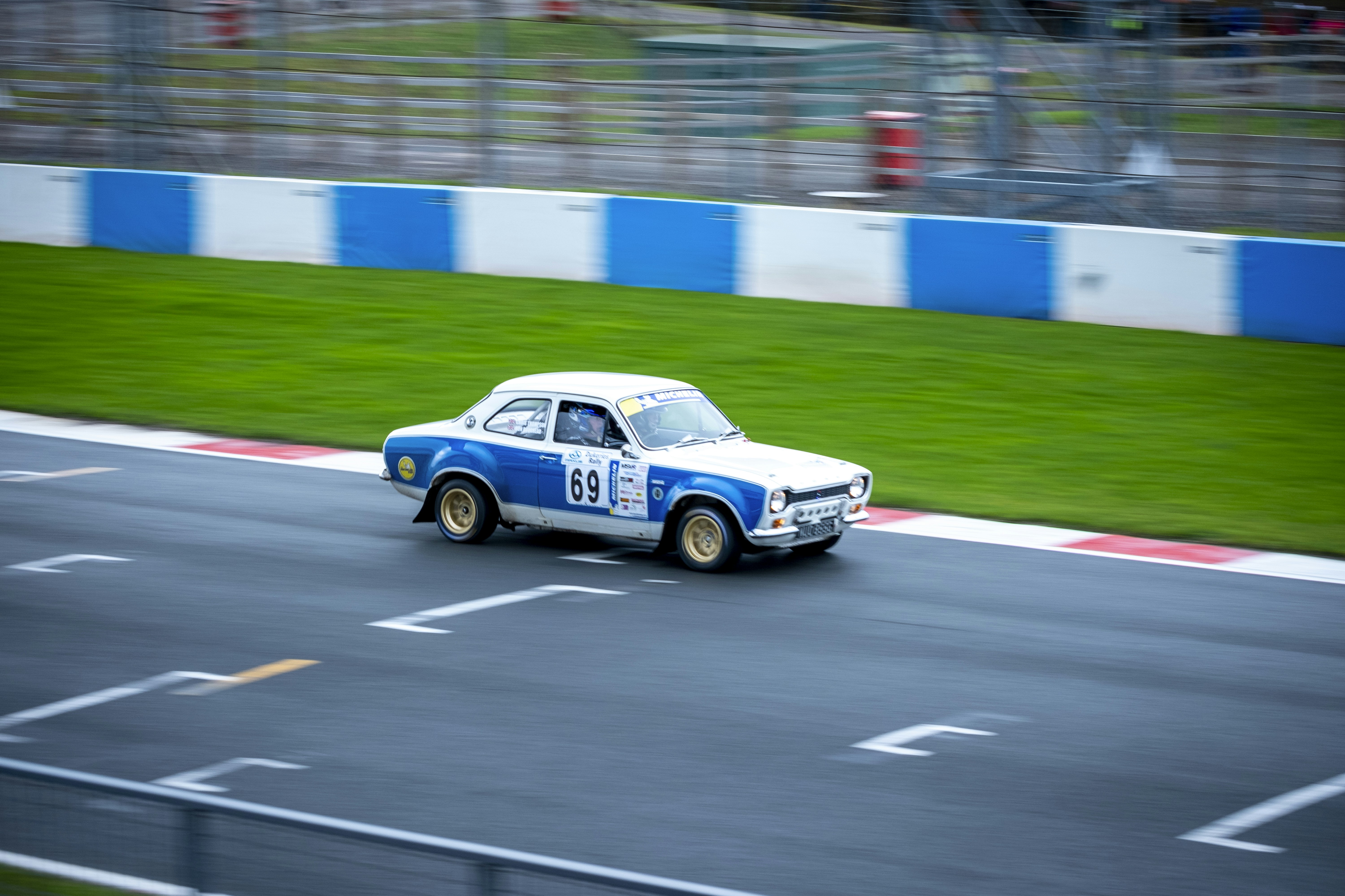 A blue and white car driving down a race track photo – Free Donington ...