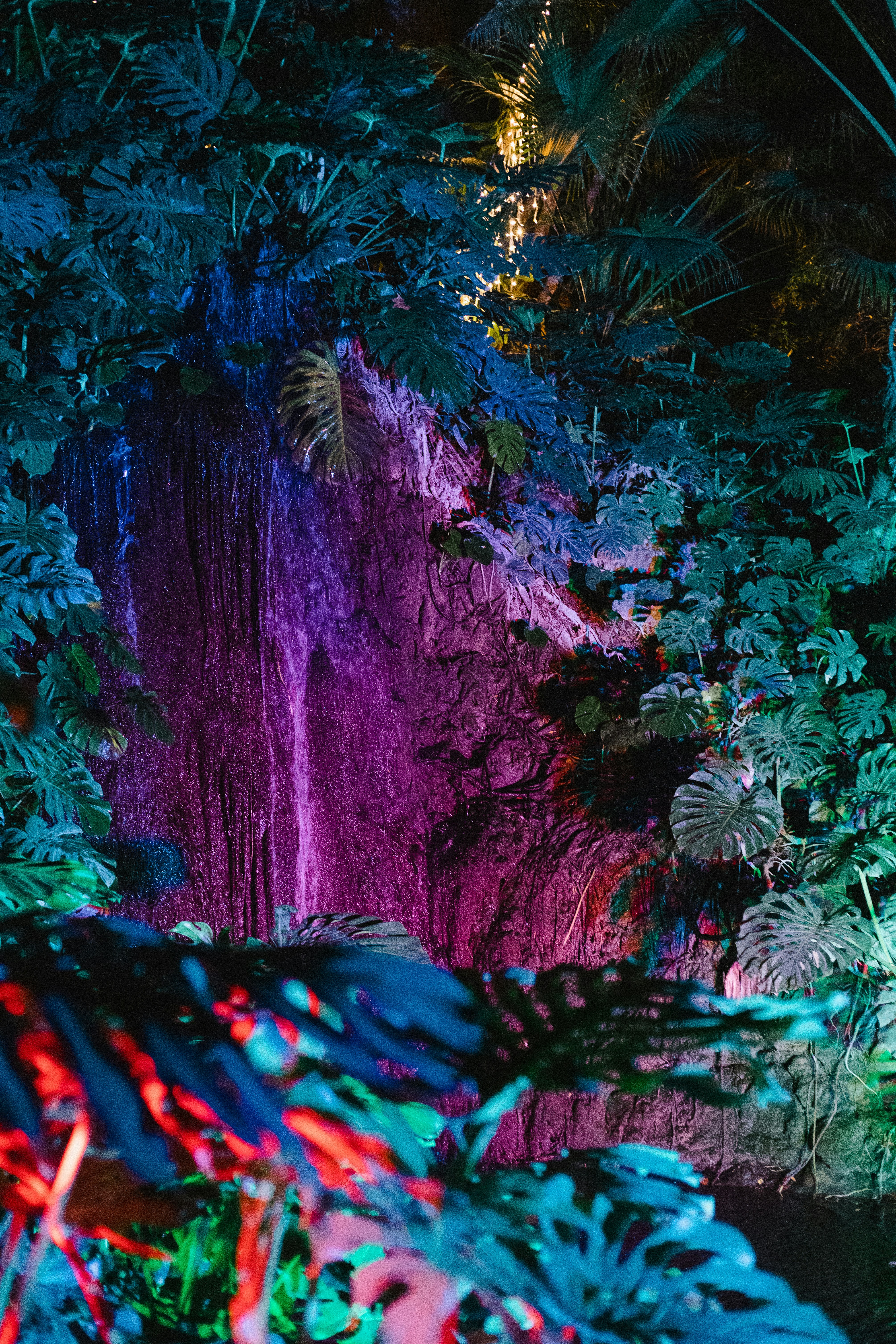 Chromatic Cascade: Neon Light on a Jungle Waterfall