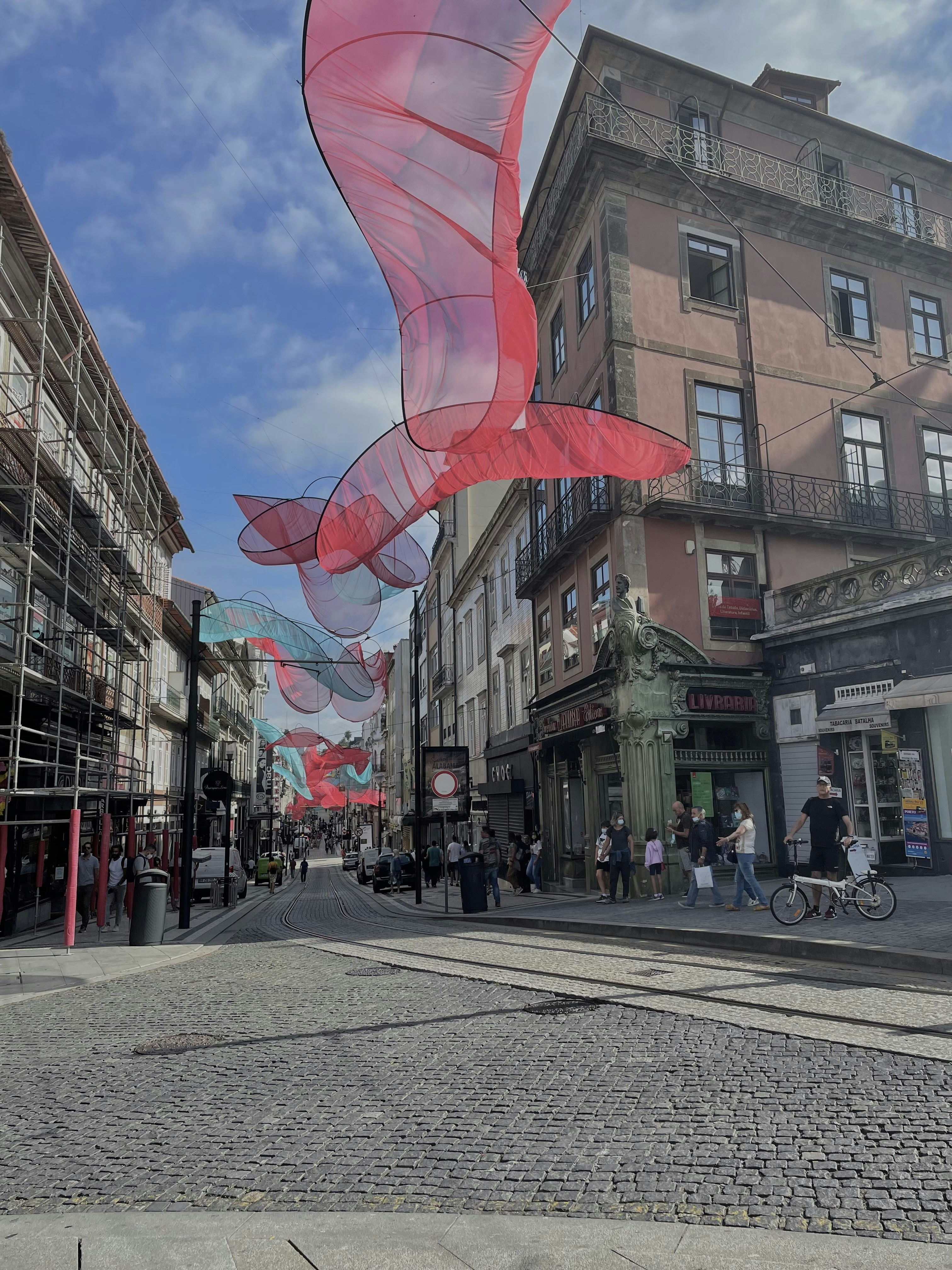 Floating crimson banners along a sunlit European street