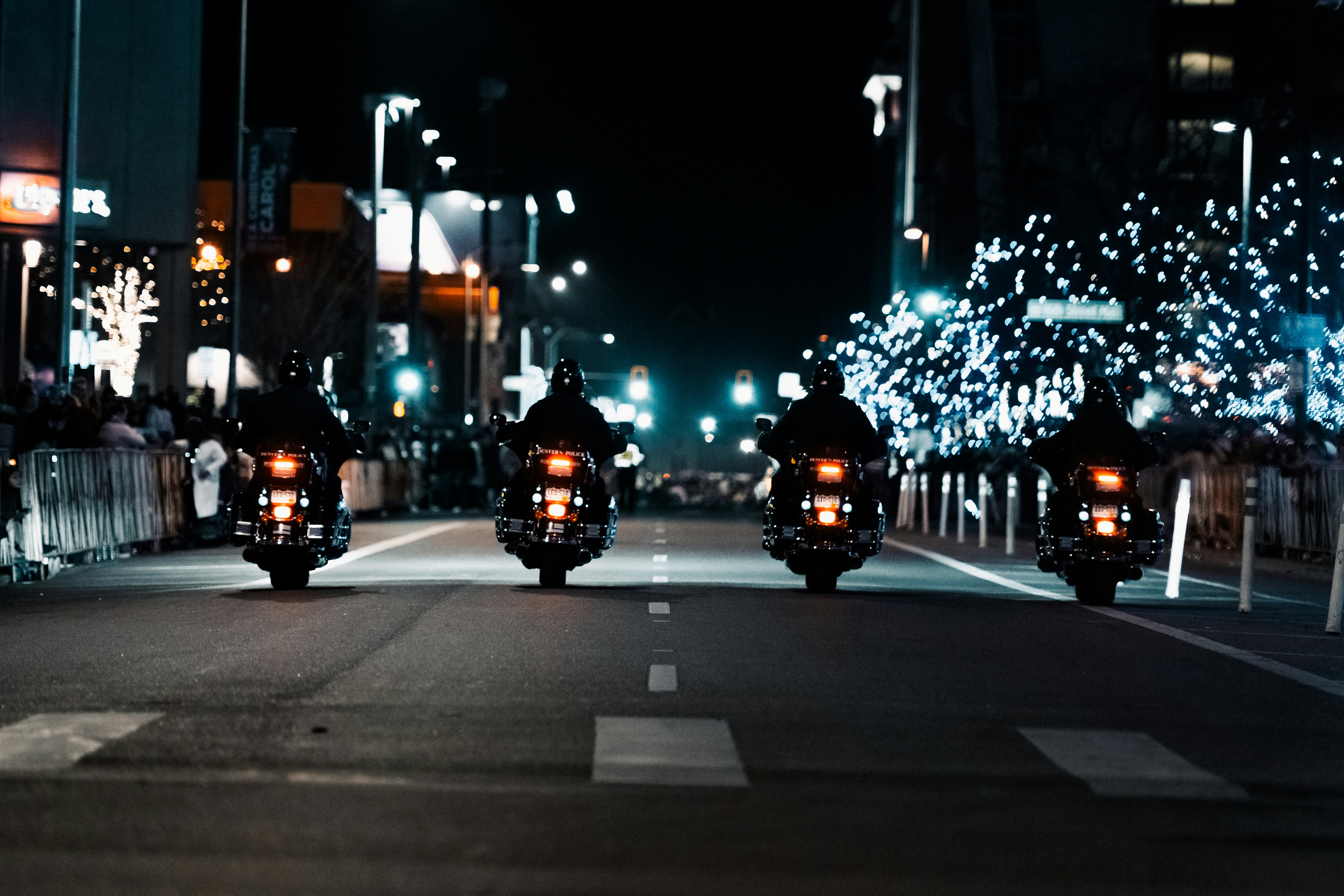 Nightfall Parade: Four Motorcycles Tracing a Neon-Lit City Street
