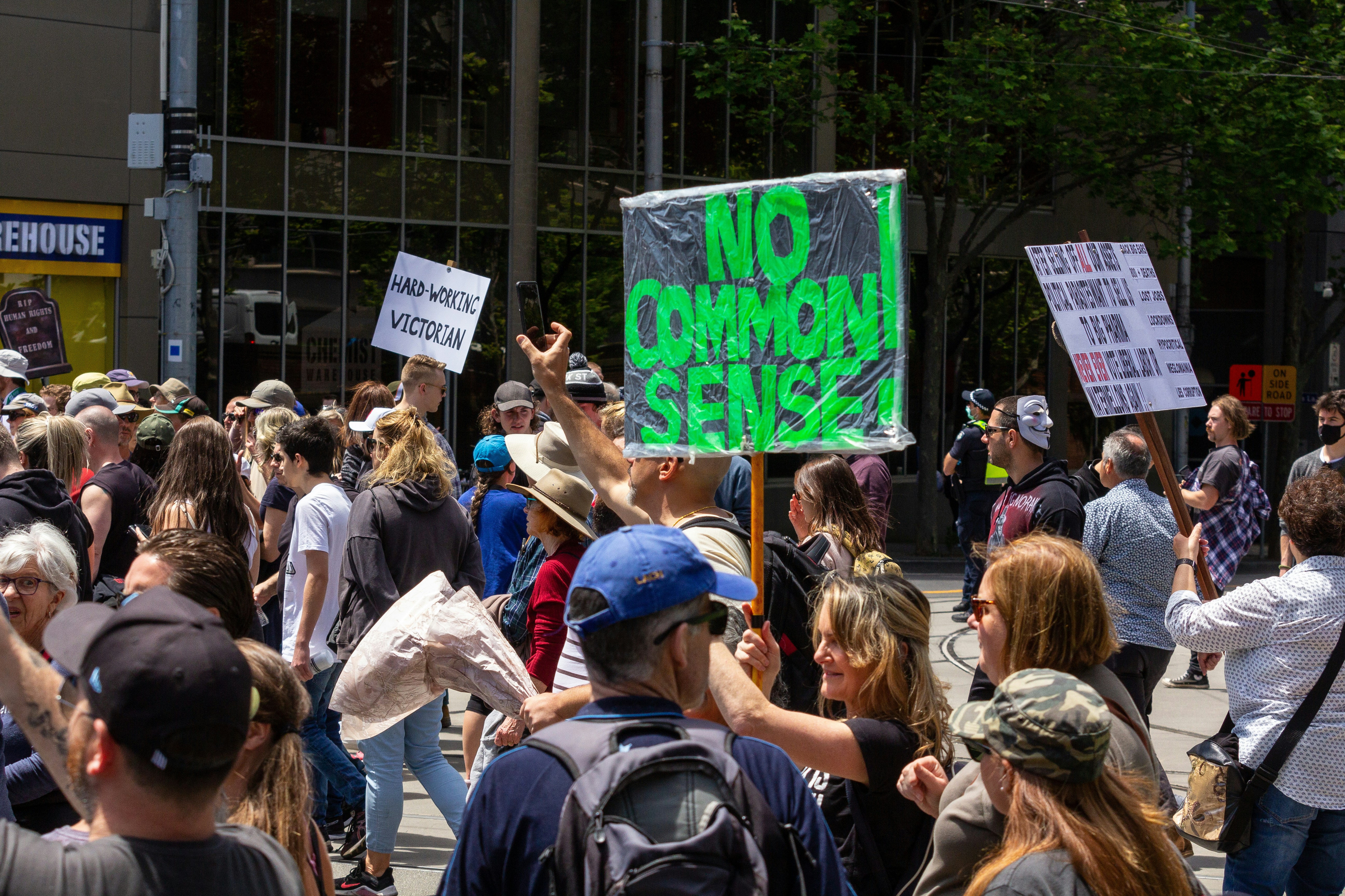 A crowd of people holding signs and protesting photo – Free Australia ...