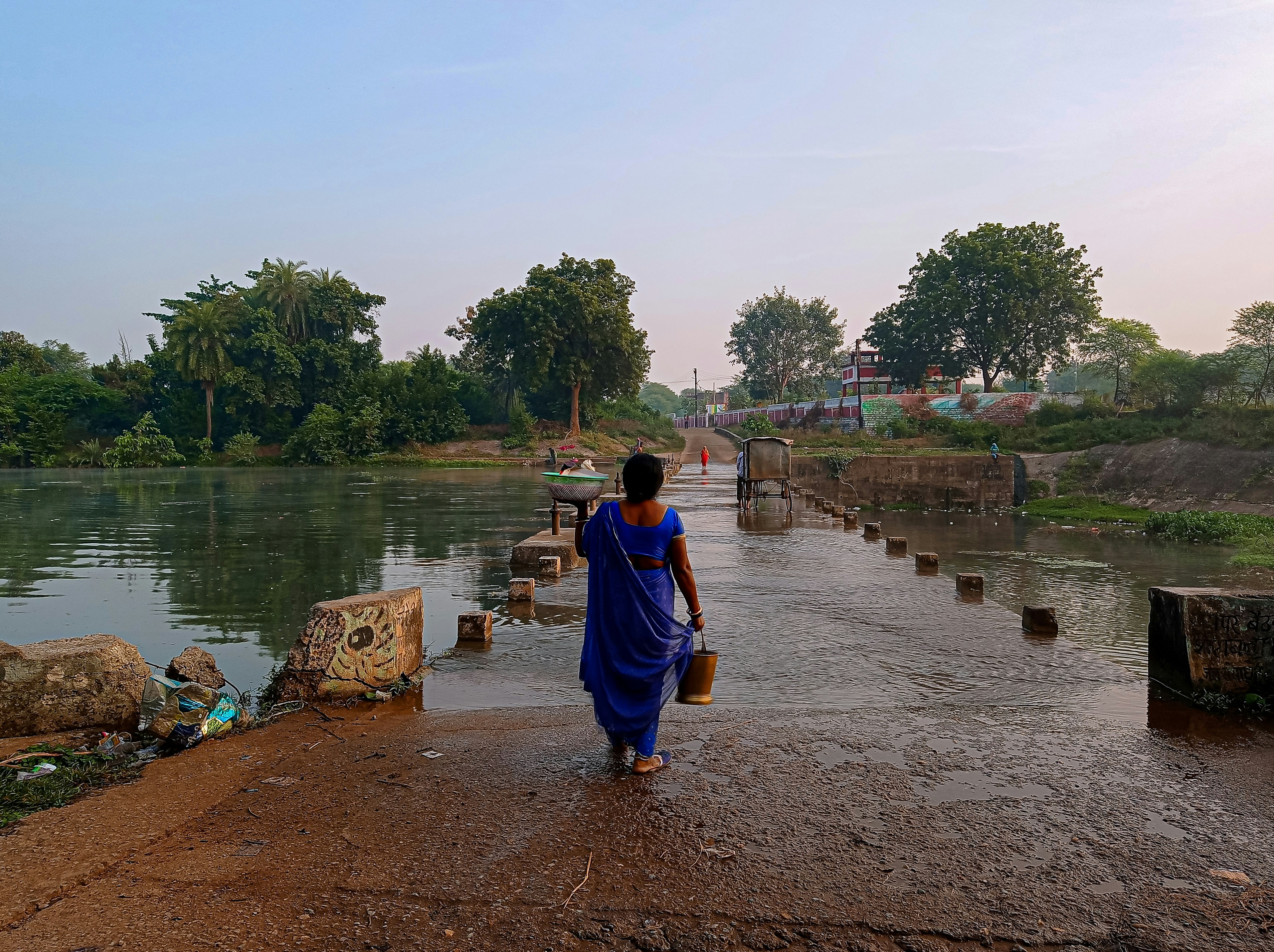 A woman in a blue sari walking along a river photo – Free Human Image ...