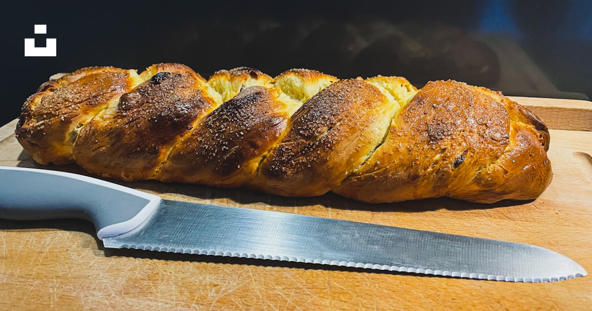 Foto Una Barra De Pan Sentada Junto A Un Cuchillo En Una Tabla De