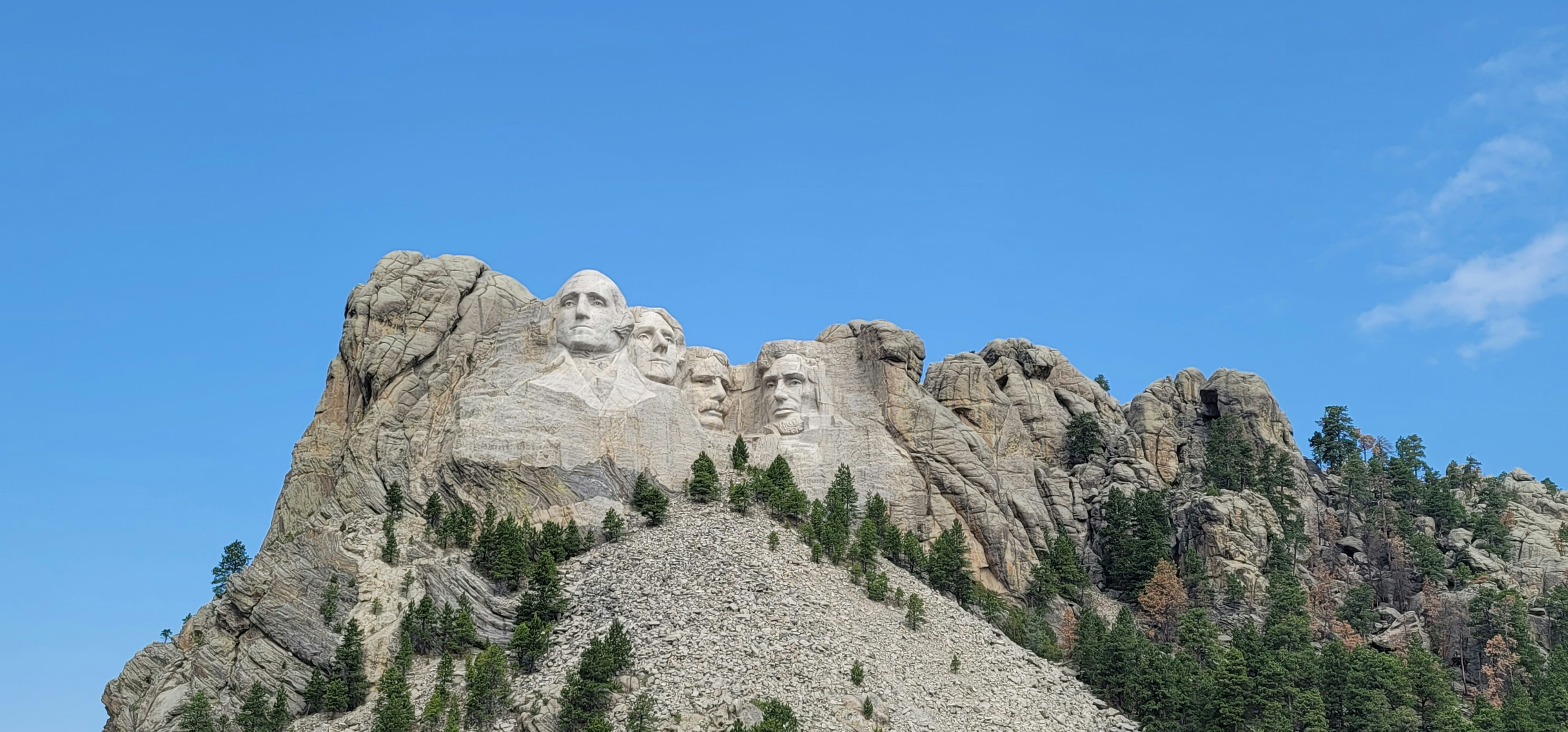 Mount Rushmore featuring the sculpted faces of four U.S. presidents against a clear blue sky.