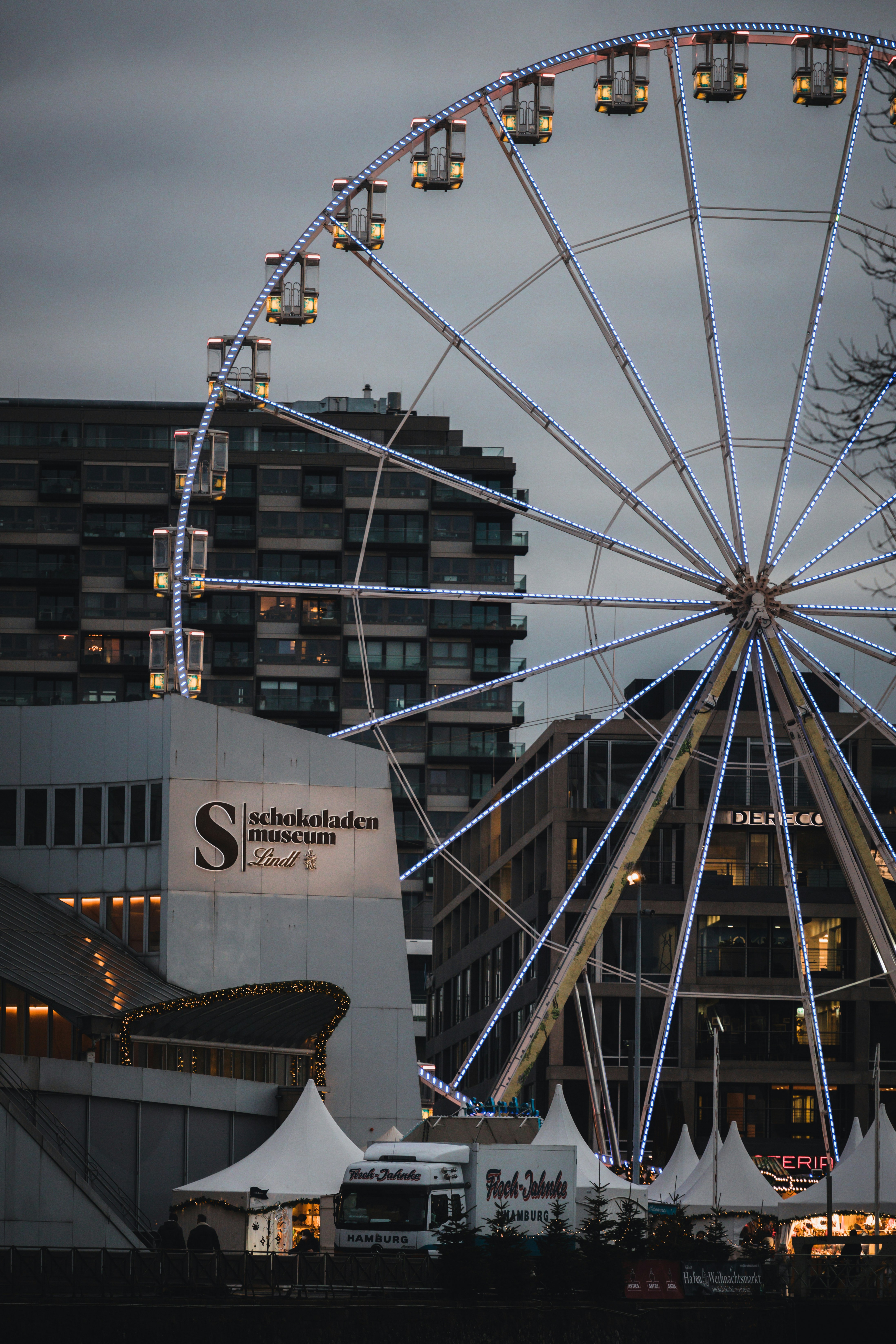 A large ferris wheel sitting in front of a tall building photo – Free ...
