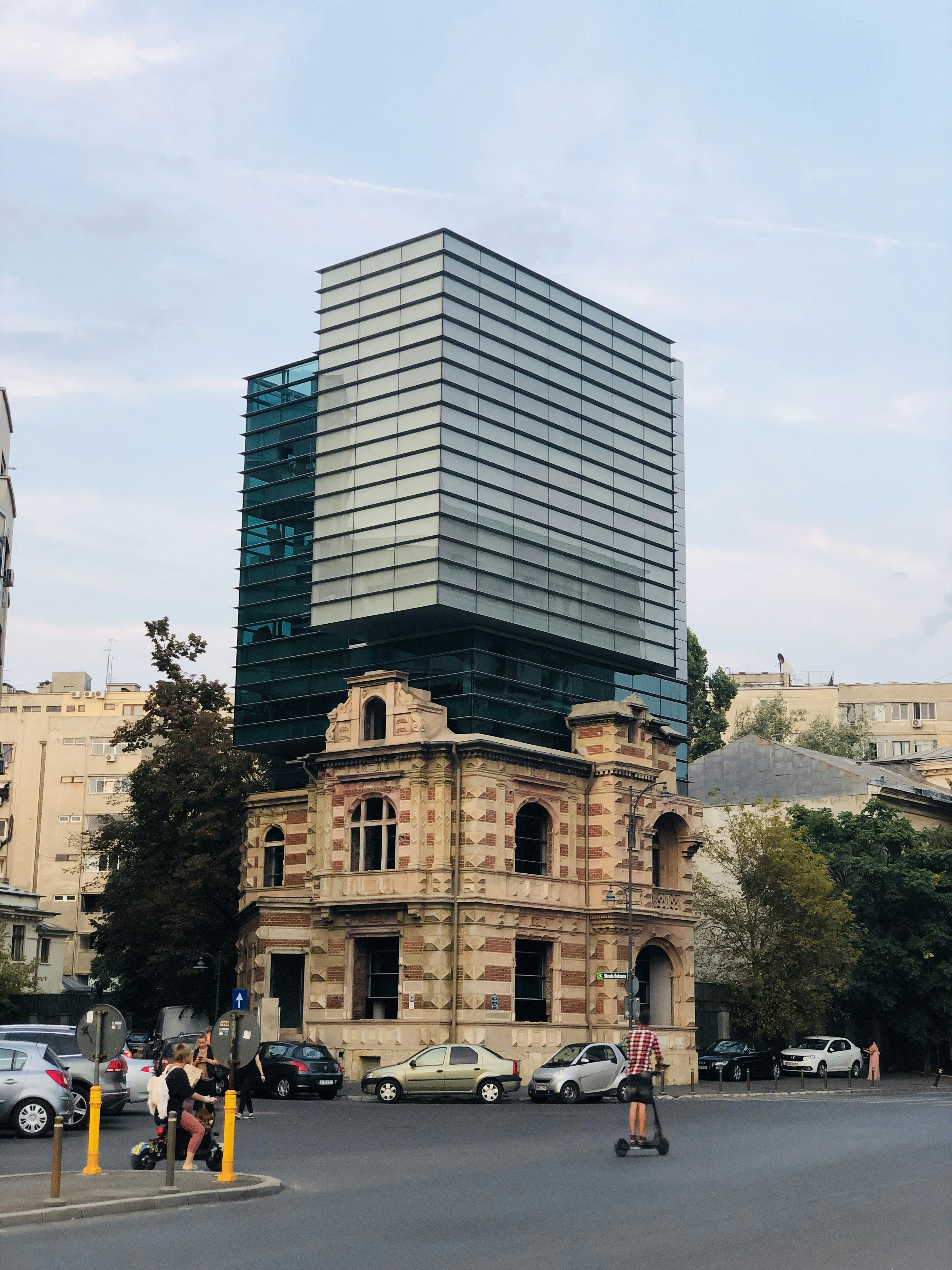 Brick Heritage Under a Glass Monolith at a Busy City Corner