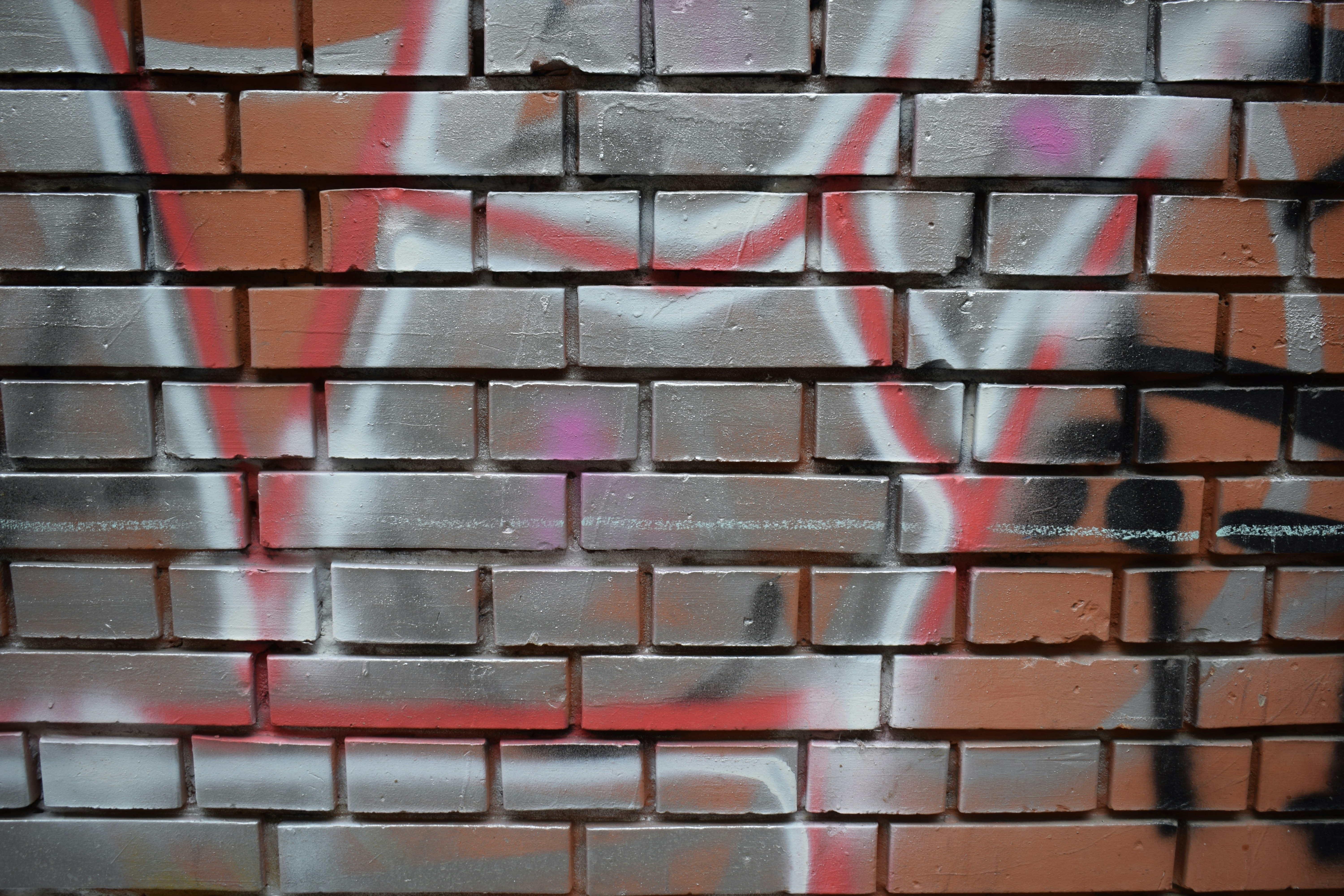 Vibrant graffiti art layered over a textured brick wall, showcasing urban creativity and expression.