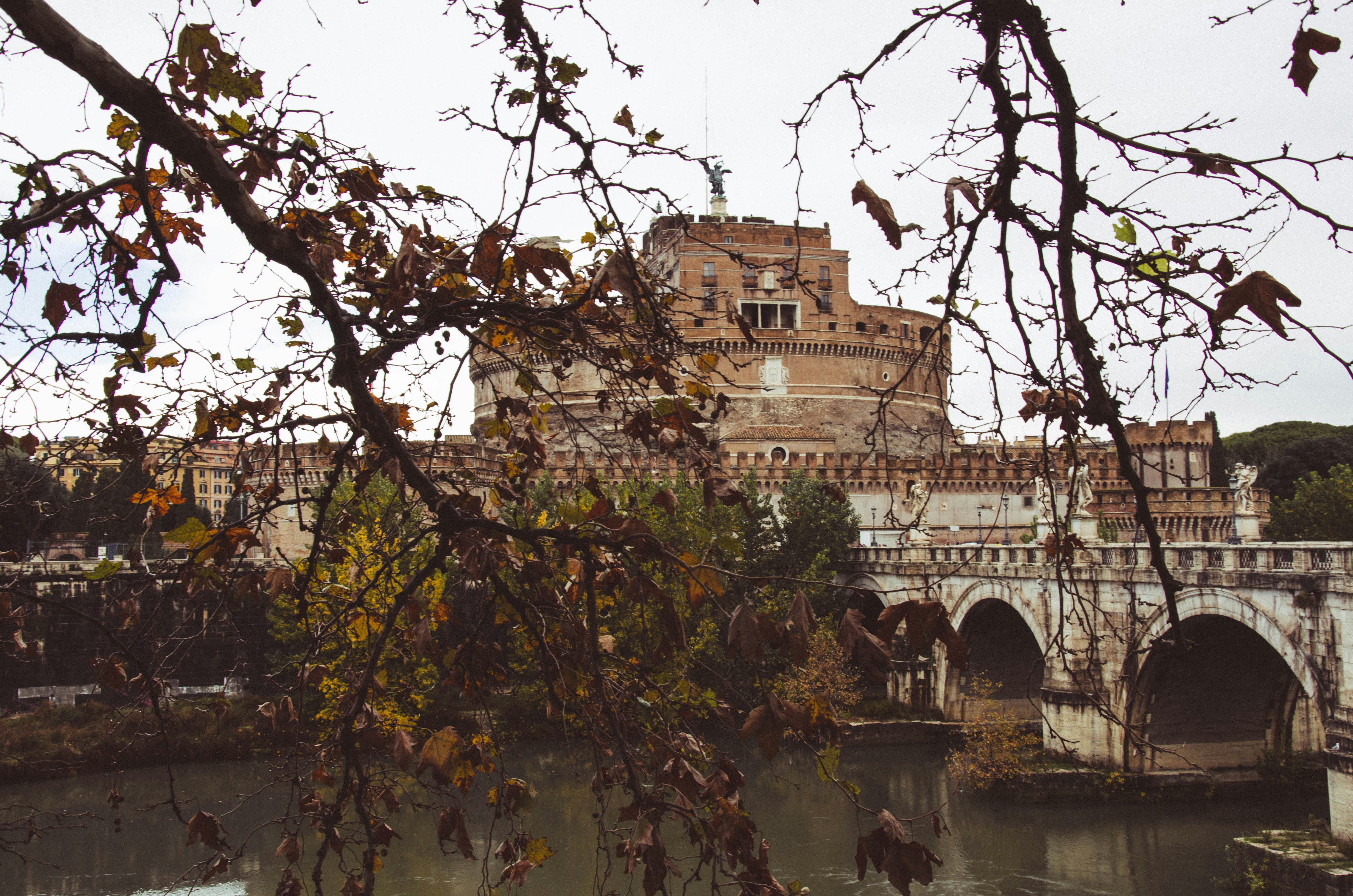 Autumn Framing: A Stone Fortress Rising Over the River Beneath Arched Bridge