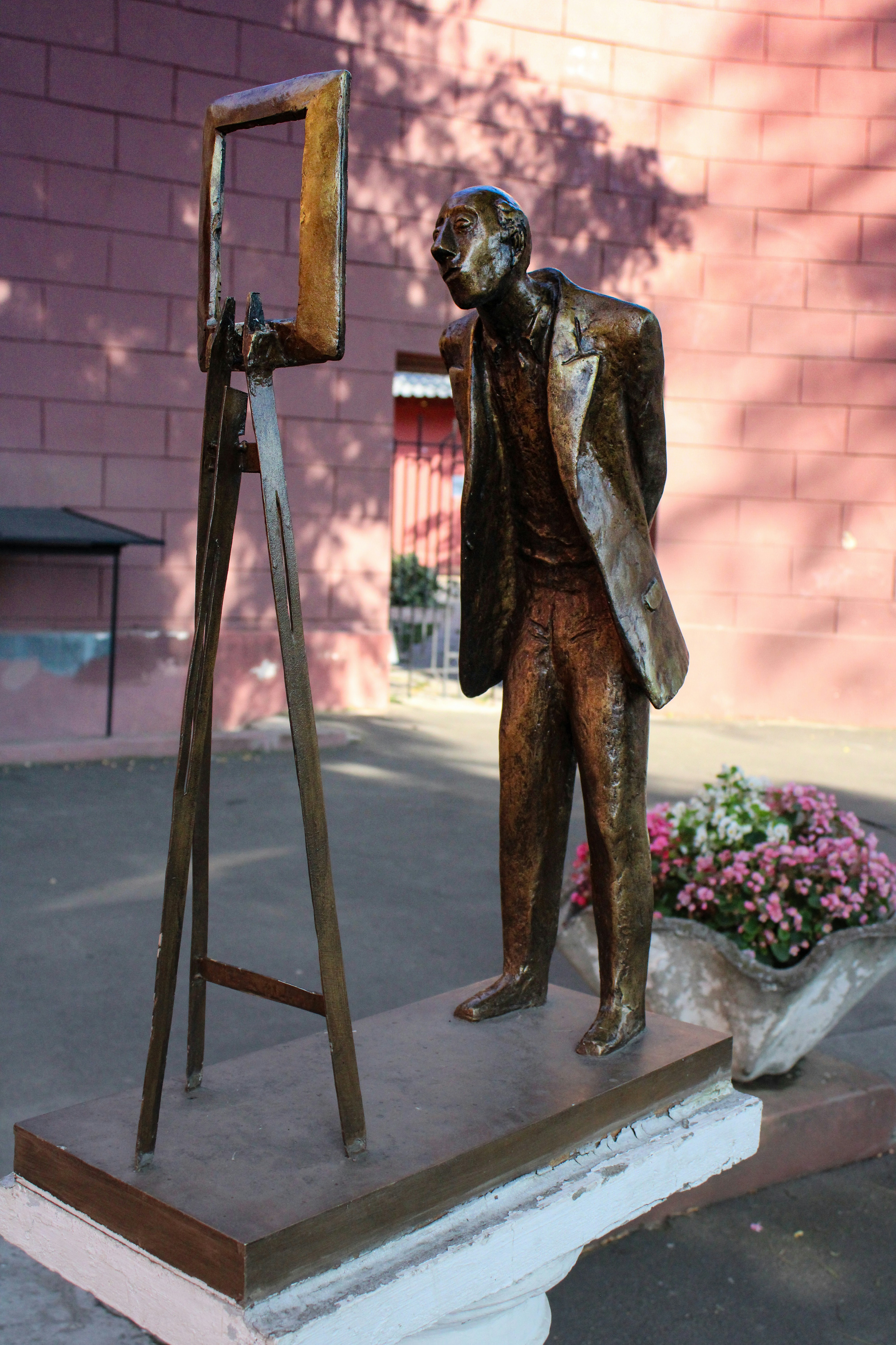 Bronze Gaze: A Figure Contemplates an Idle Frame in Sunlit Plaza