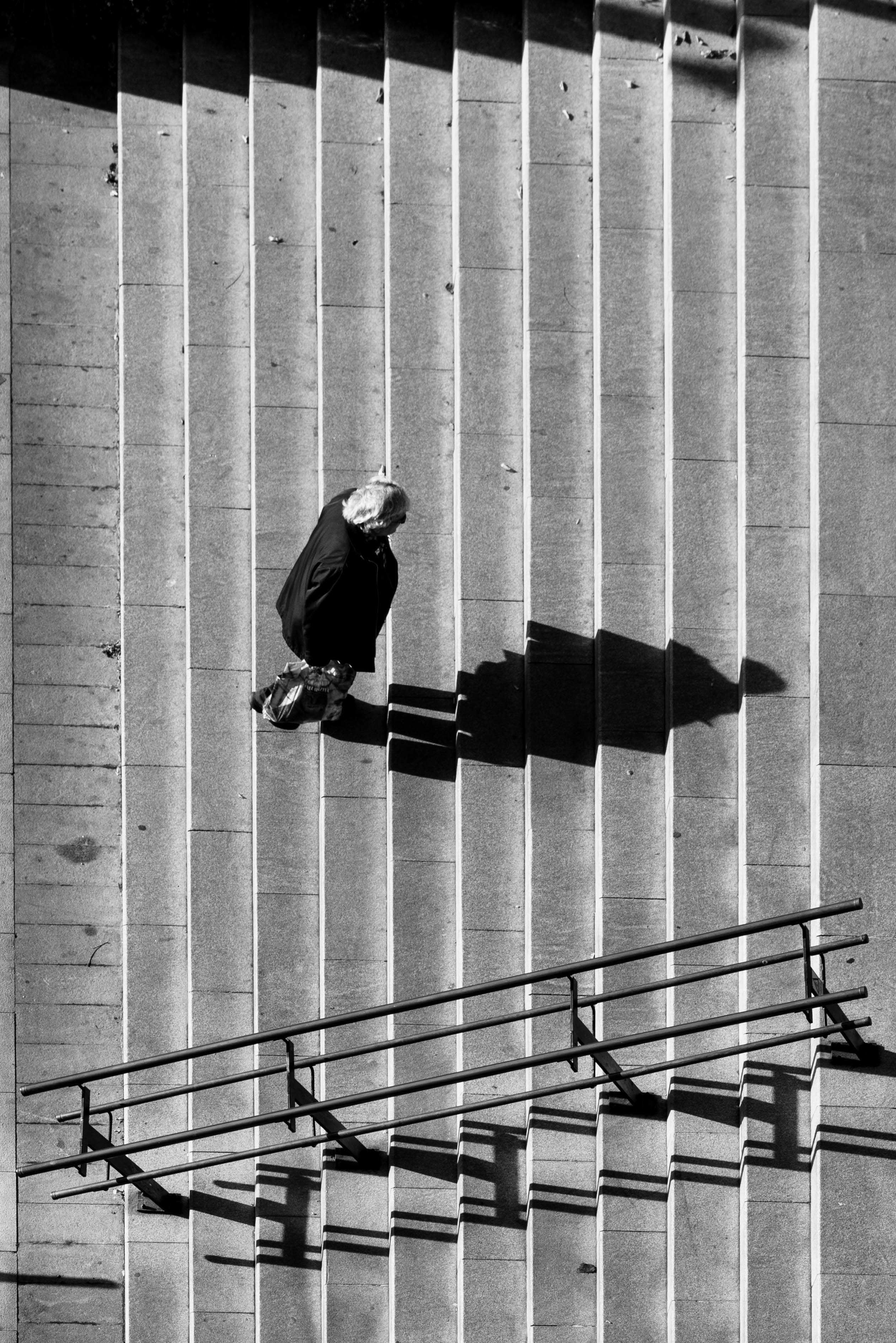 Edge of Light: A Lone Pedestrian on a Diagonal Staircase