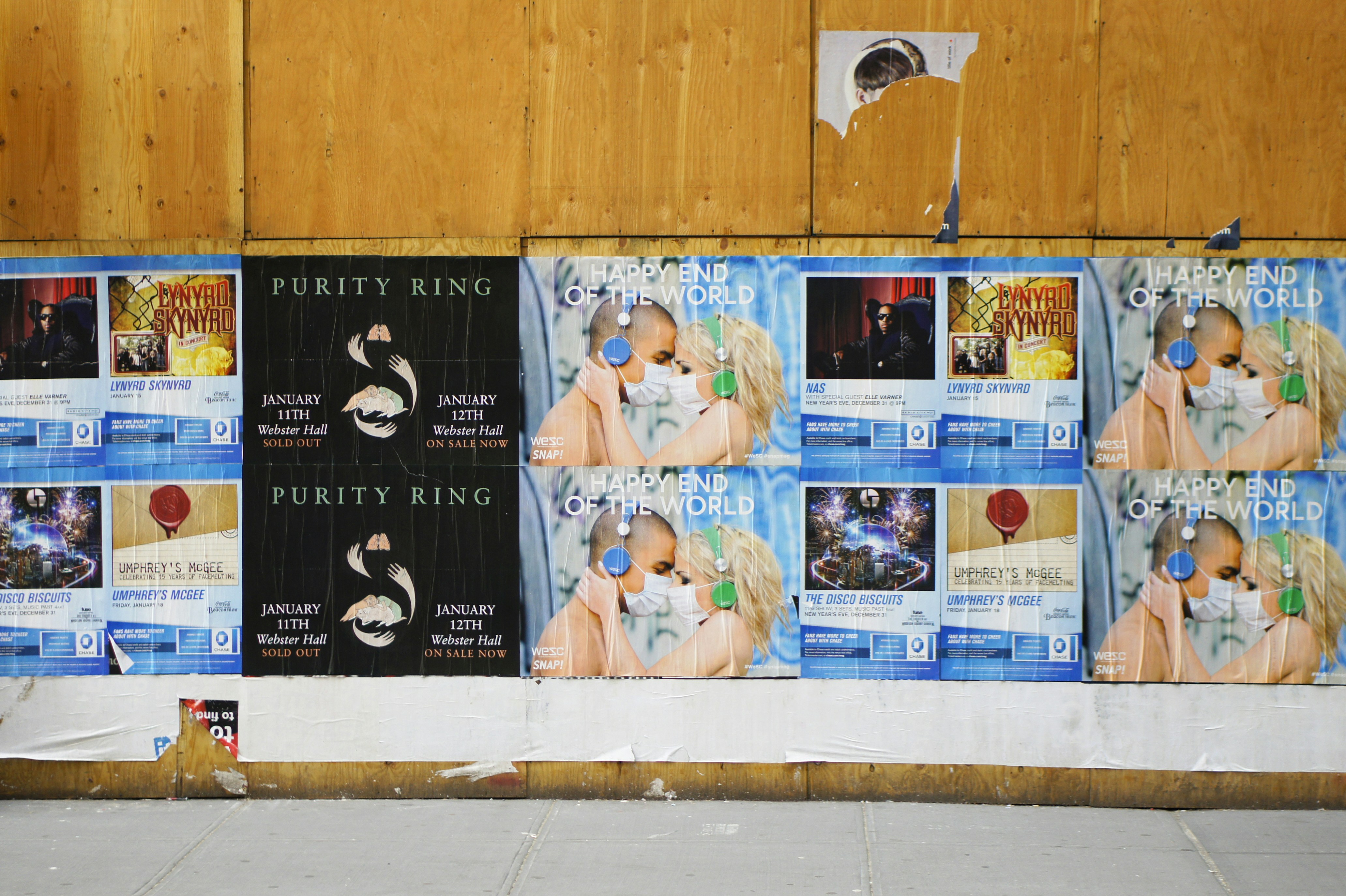 A bunch of posters on the side of a building photo – Free Poster Image ...