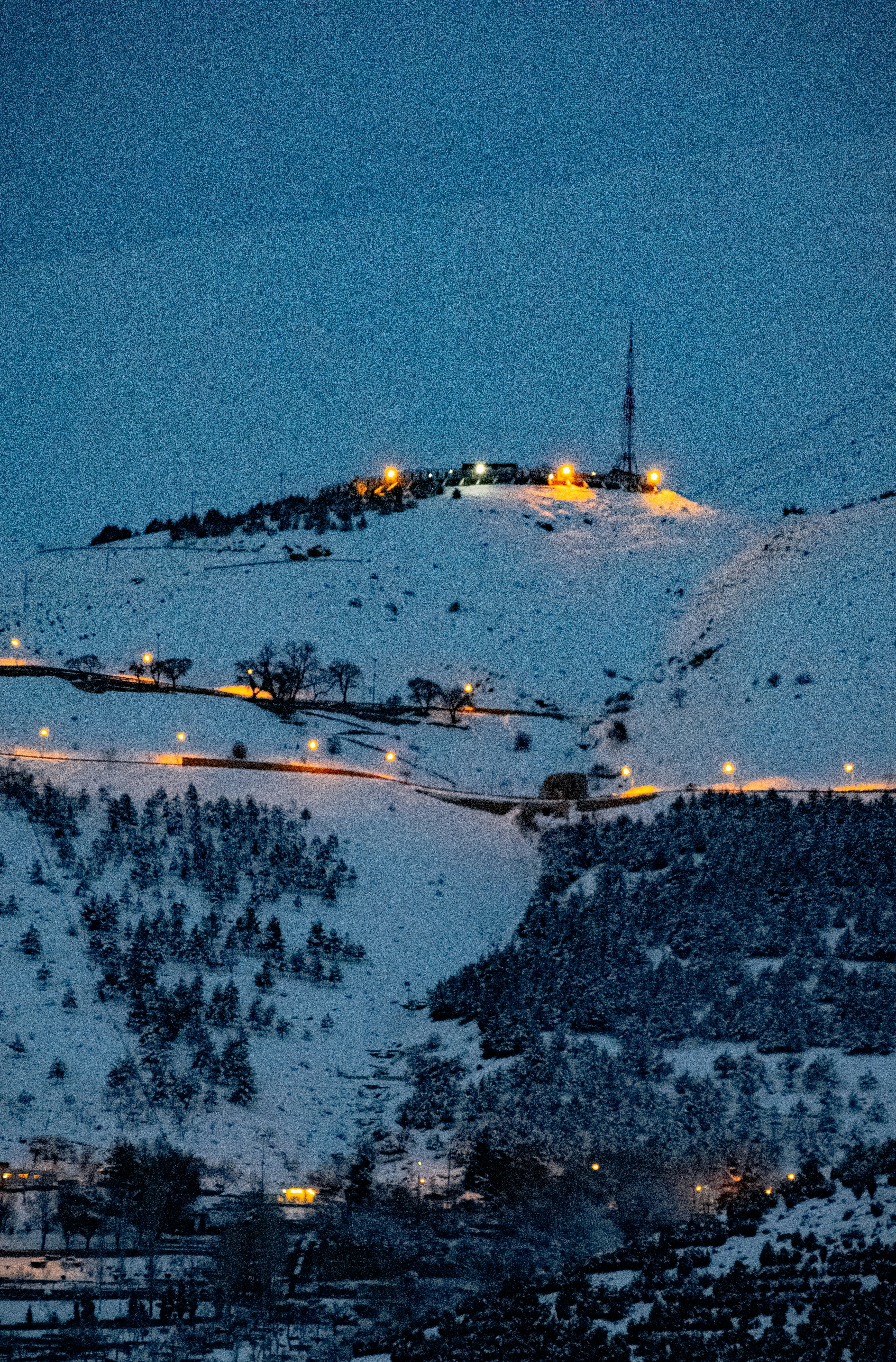 Snowlit hilltop with beacon lights and communication tower