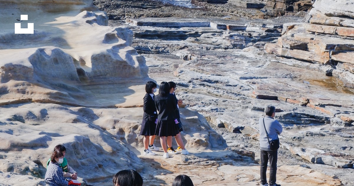 바위 해변 꼭대기에 서있는 사람들의 그룹 사진 Unsplash의 무료 일본 이미지