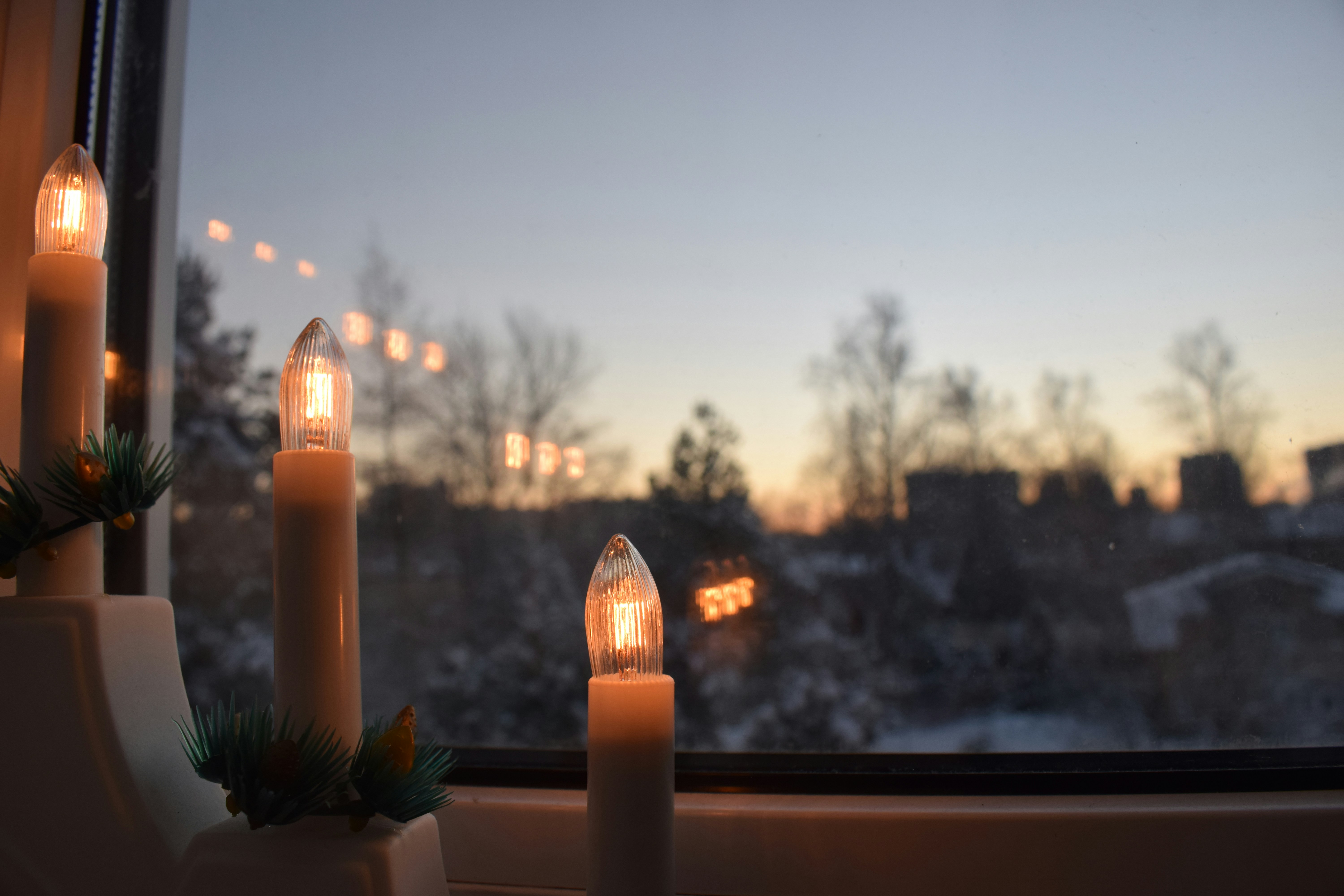 a couple of candles sitting on top of a window sill