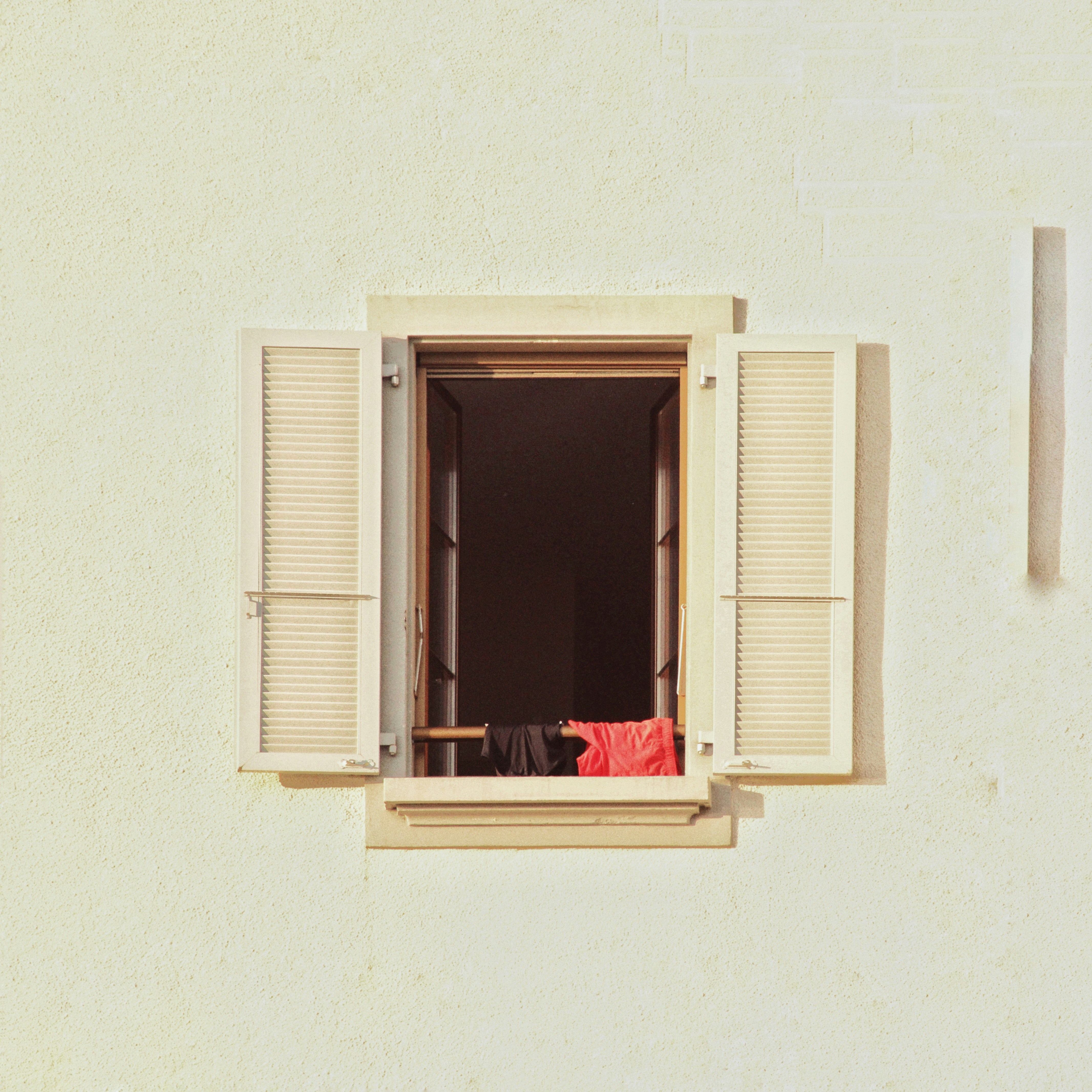 Pastel Pane: Open Shutters and a Red Laundry Accent