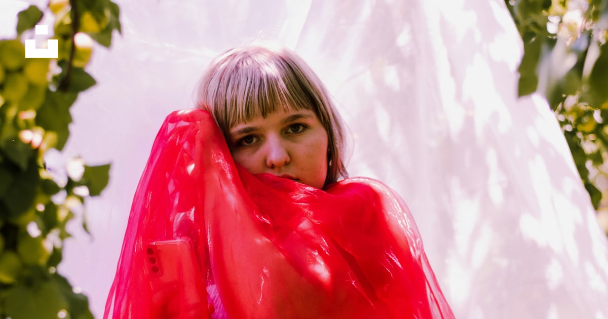 Foto Una Mujer Con Un Vestido Rojo Está Parada Debajo De Un árbol