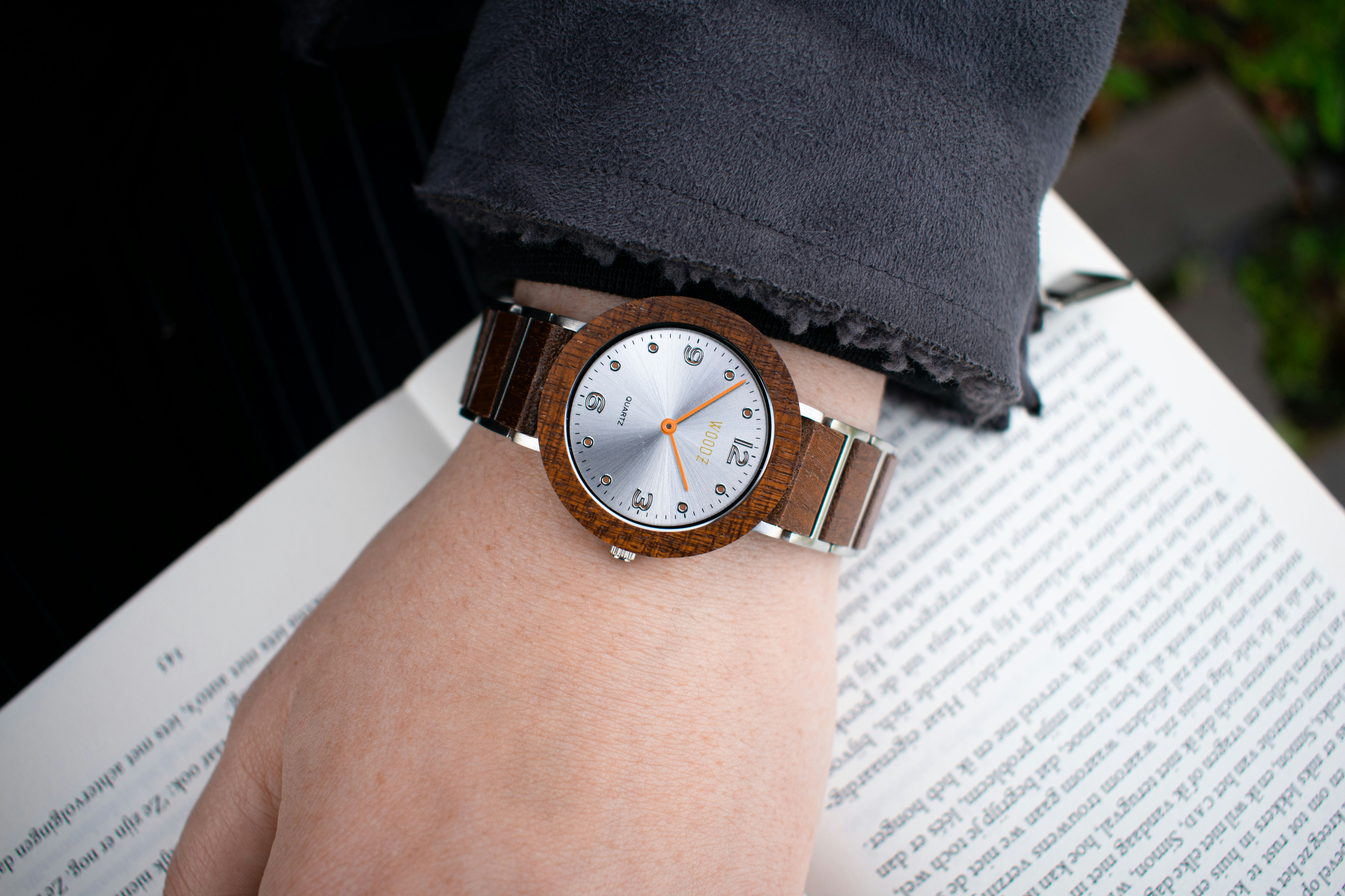 Paperbound Time: A Wooden-Bezel Watch Resting on a Printed Page