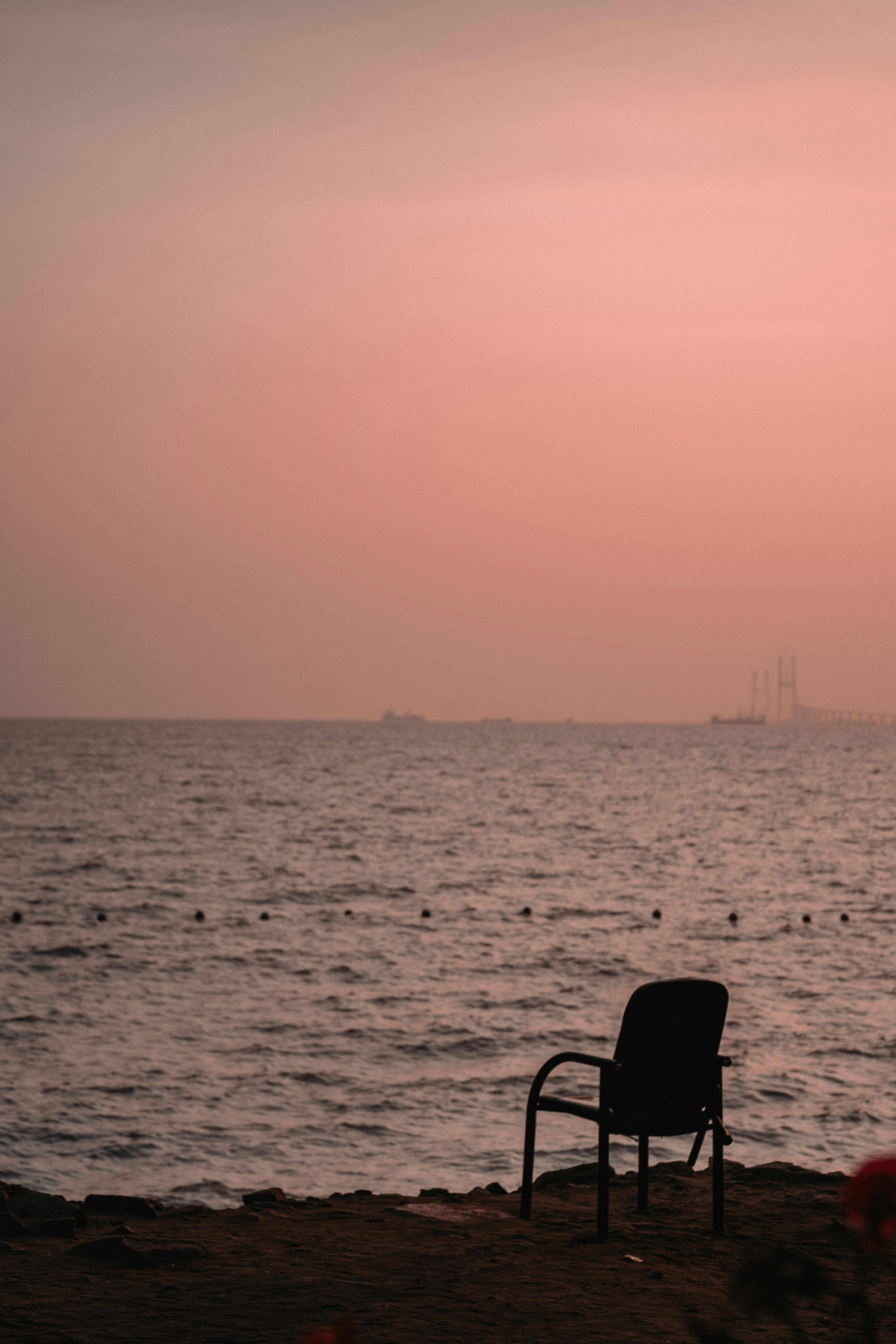 a chair sitting on the shore of a body of water