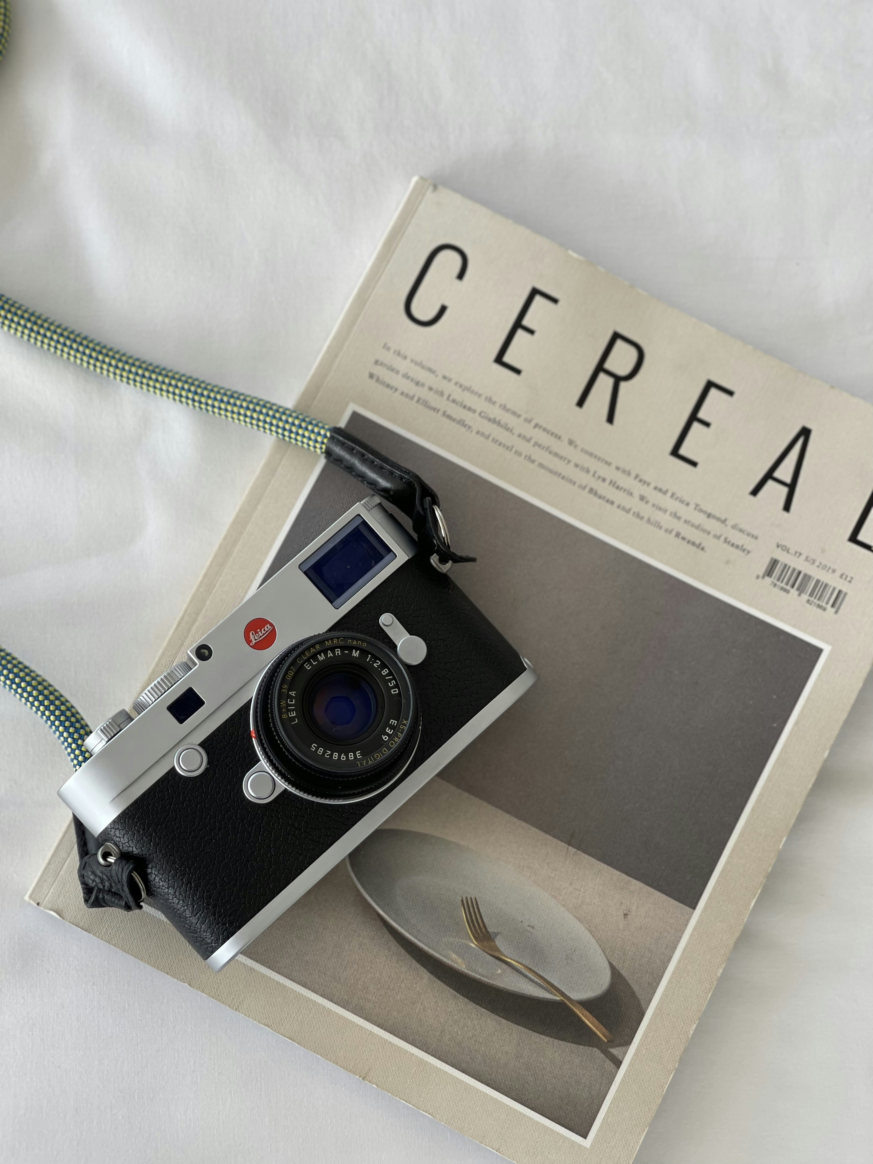 Silver Leica-esque Rangefinder resting on a magazine titled Cereal