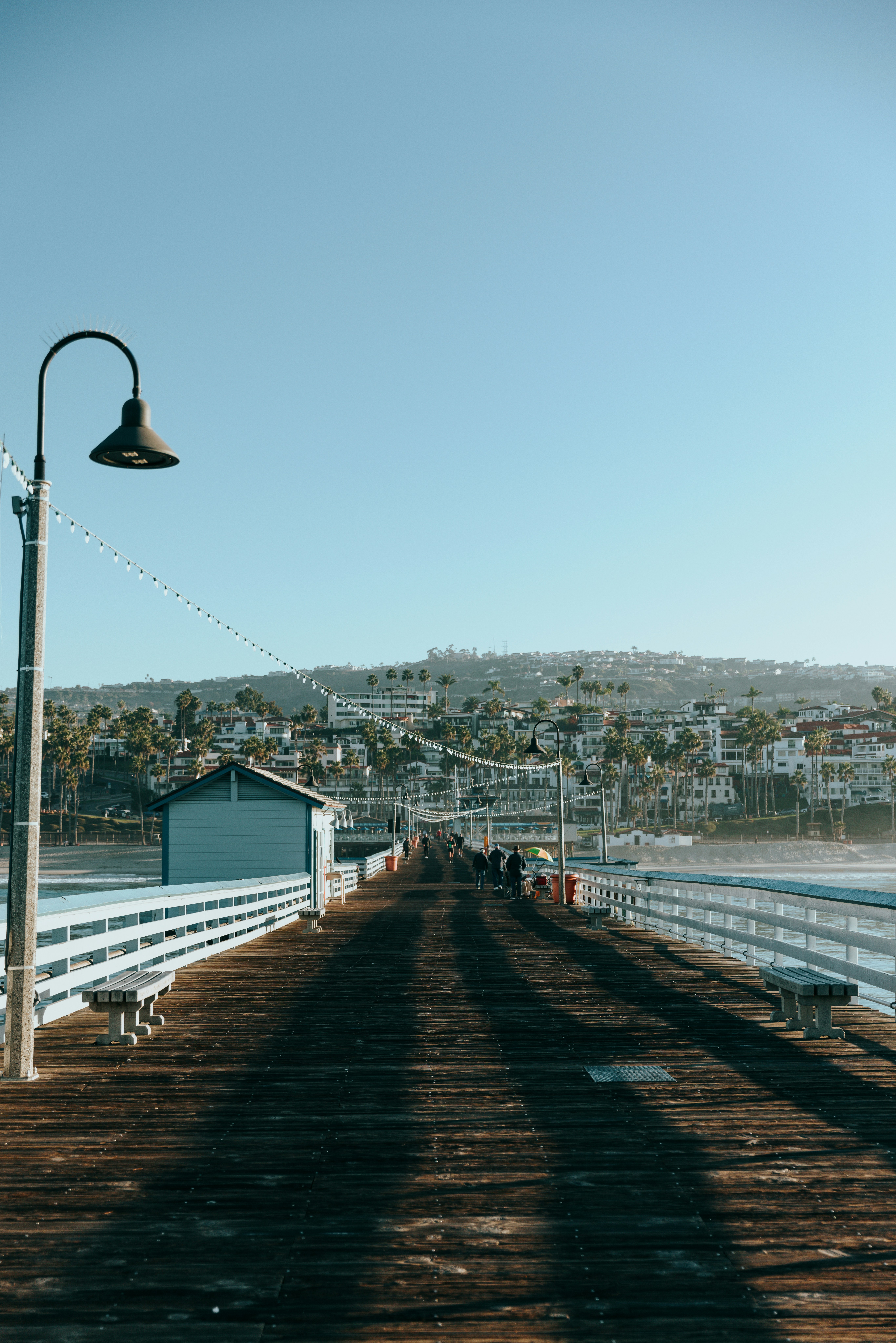 A wooden pier with a light pole and a street lamp photo – Free Water ...