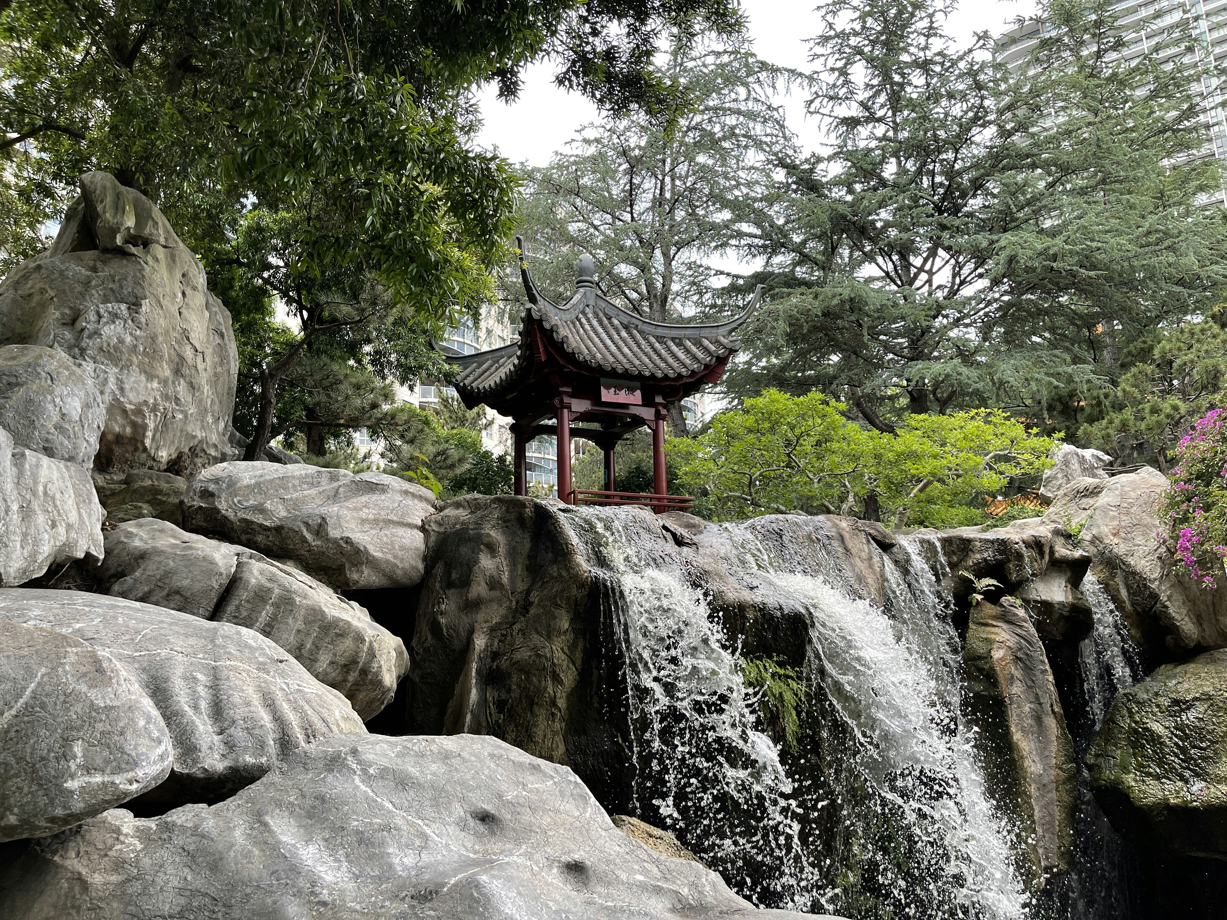 Crimson Pavilion Crowned by a Gentle Cascade