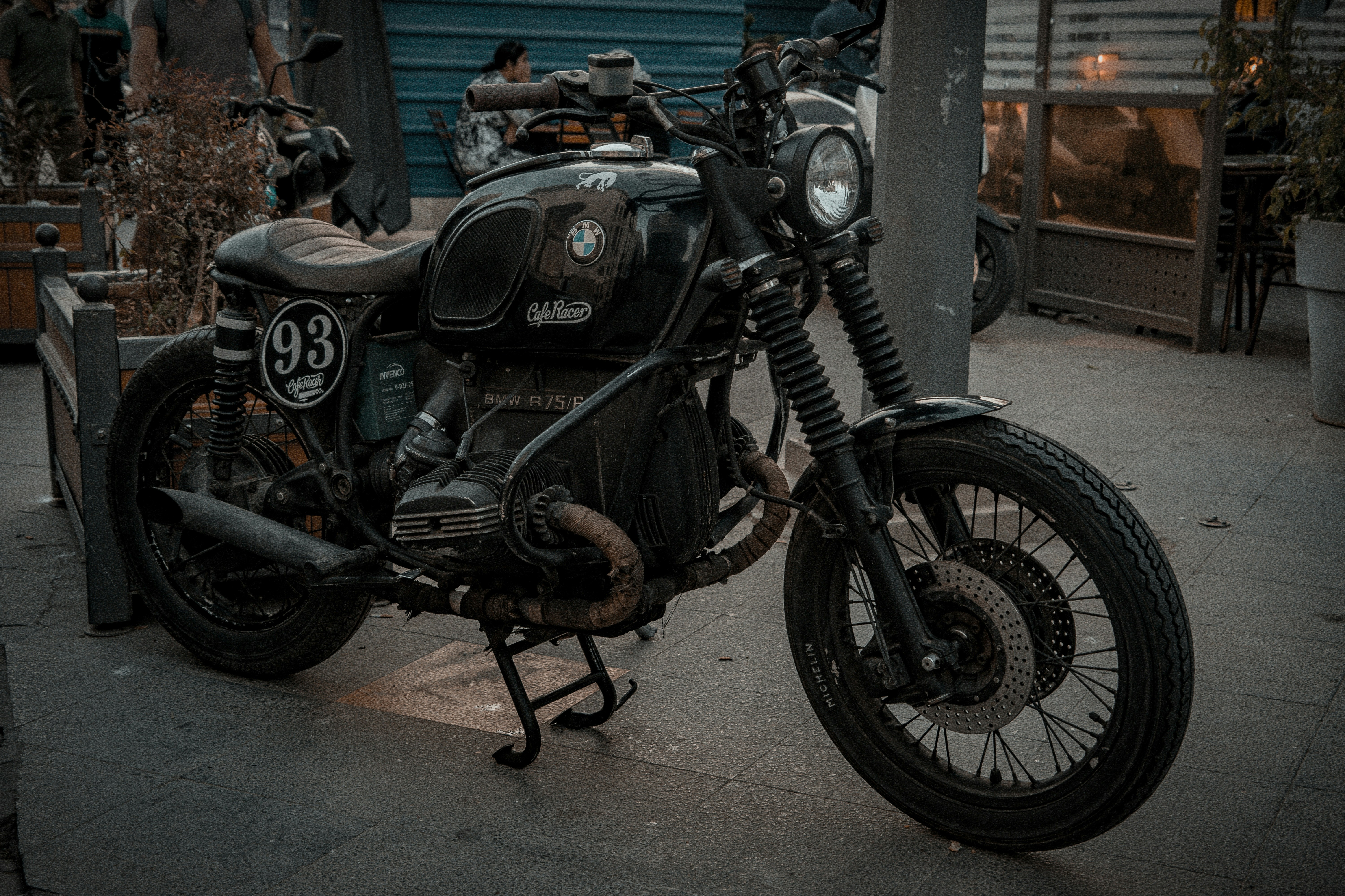 Vintage motorcycle parked in an industrial setting with a weathered backdrop.