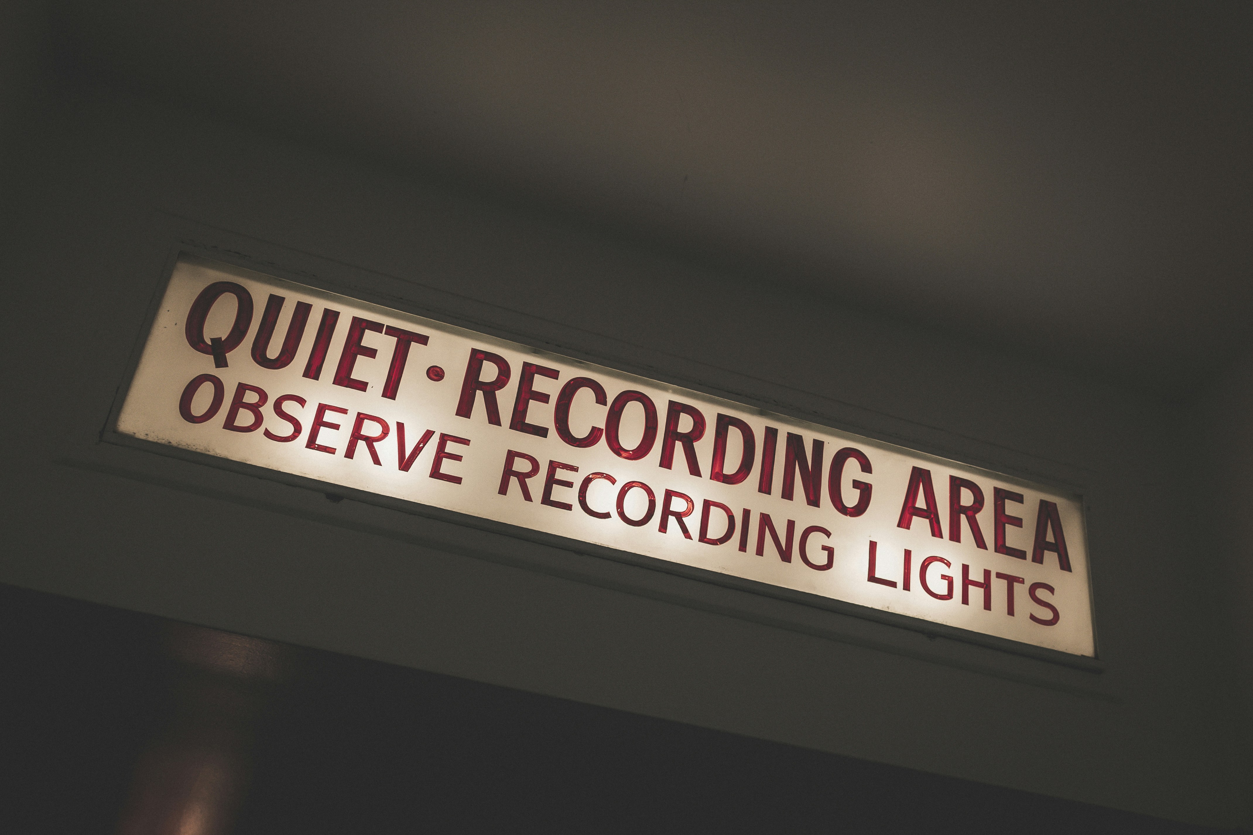 A red and white sign that reads quiet recording area observeive ...
