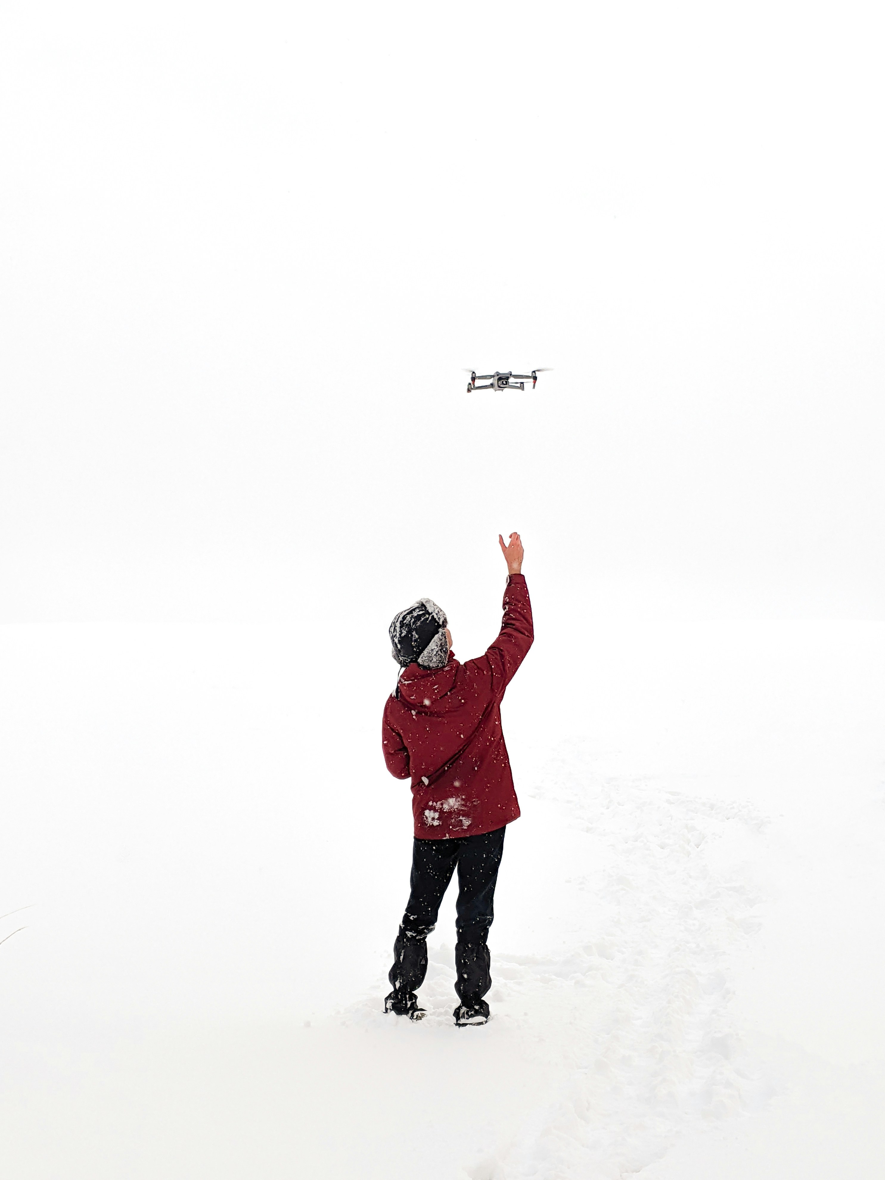 A person standing in the snow flying a kite photo – Free Brown Image on ...