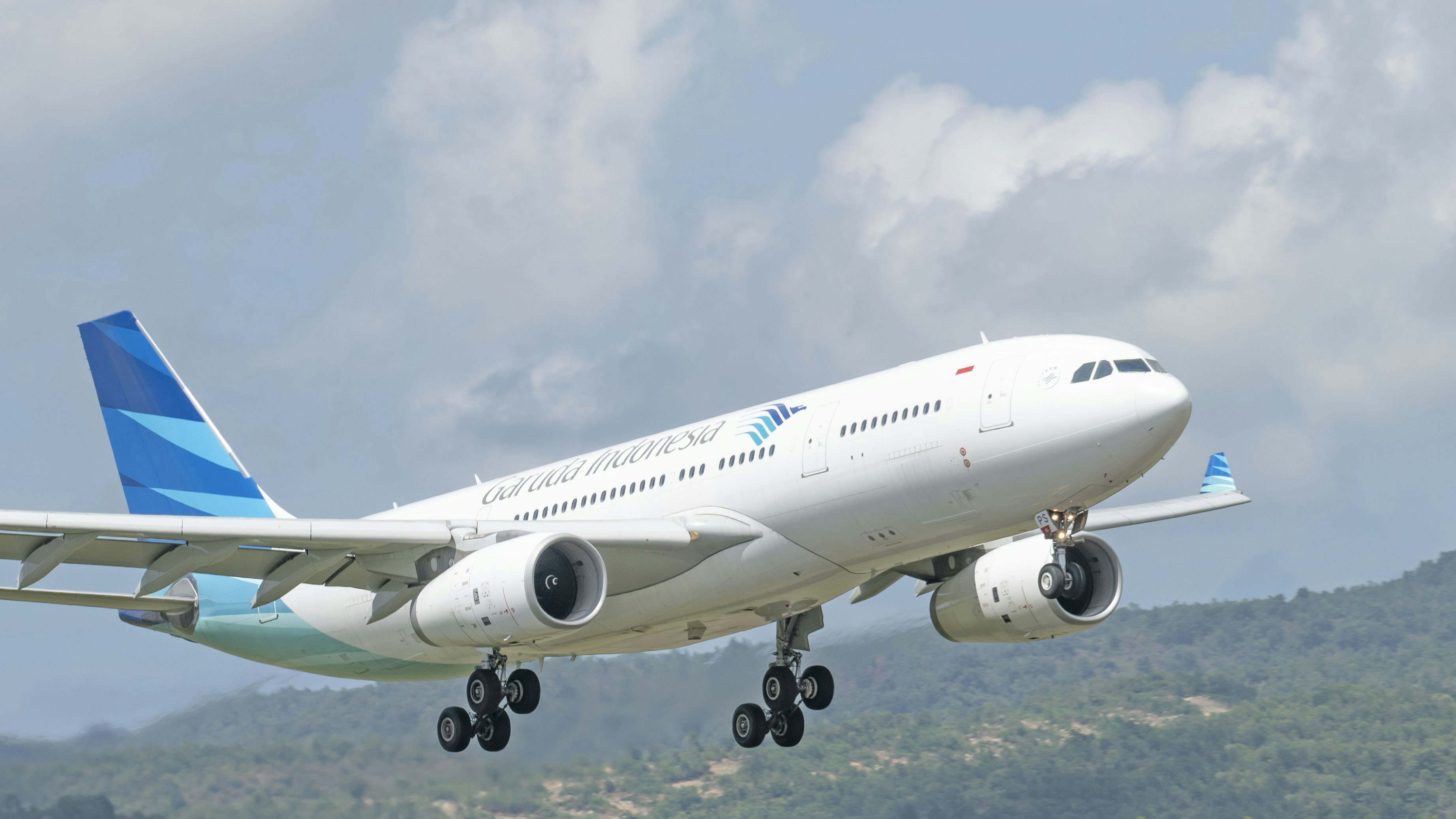 A large passenger jet flying through a cloudy sky photo – Free Airplane ...