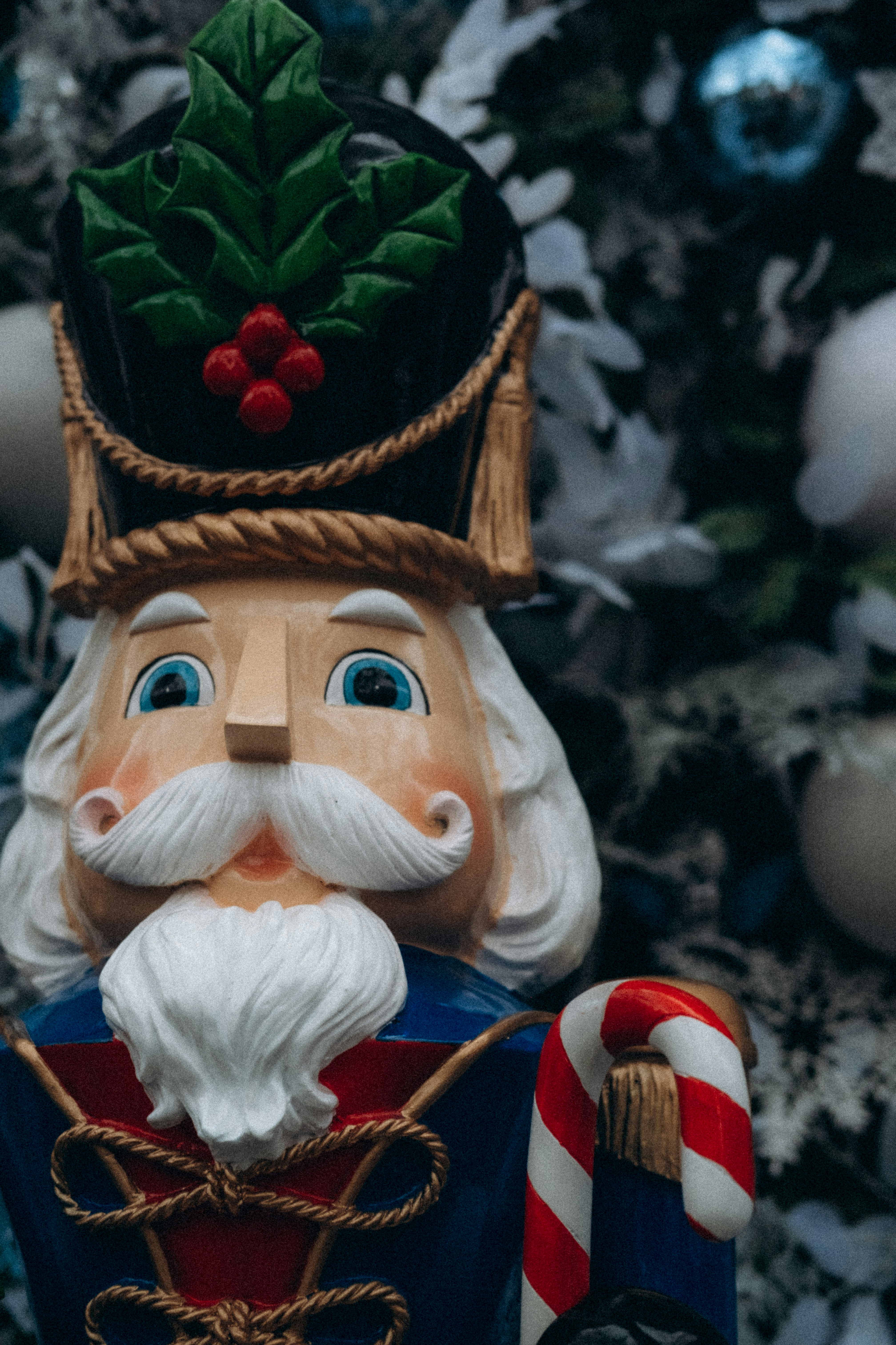 Holly-Crowned Nutcracker: A Festive Sentinel Amid Frosted Foliage
