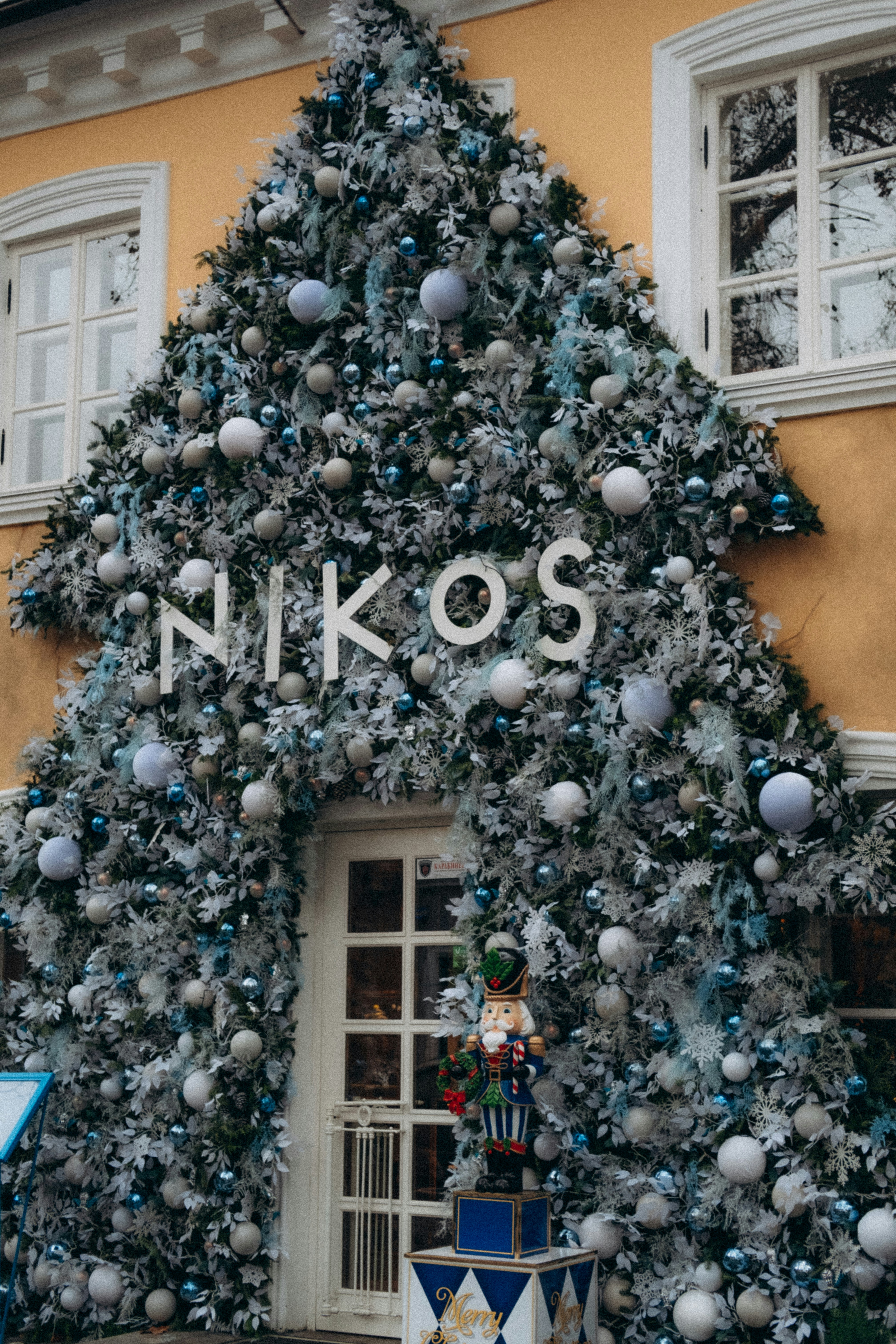 NIKOS Christmas Tree: A Frosted Facade Wrapped in Silver and Blue Ornaments