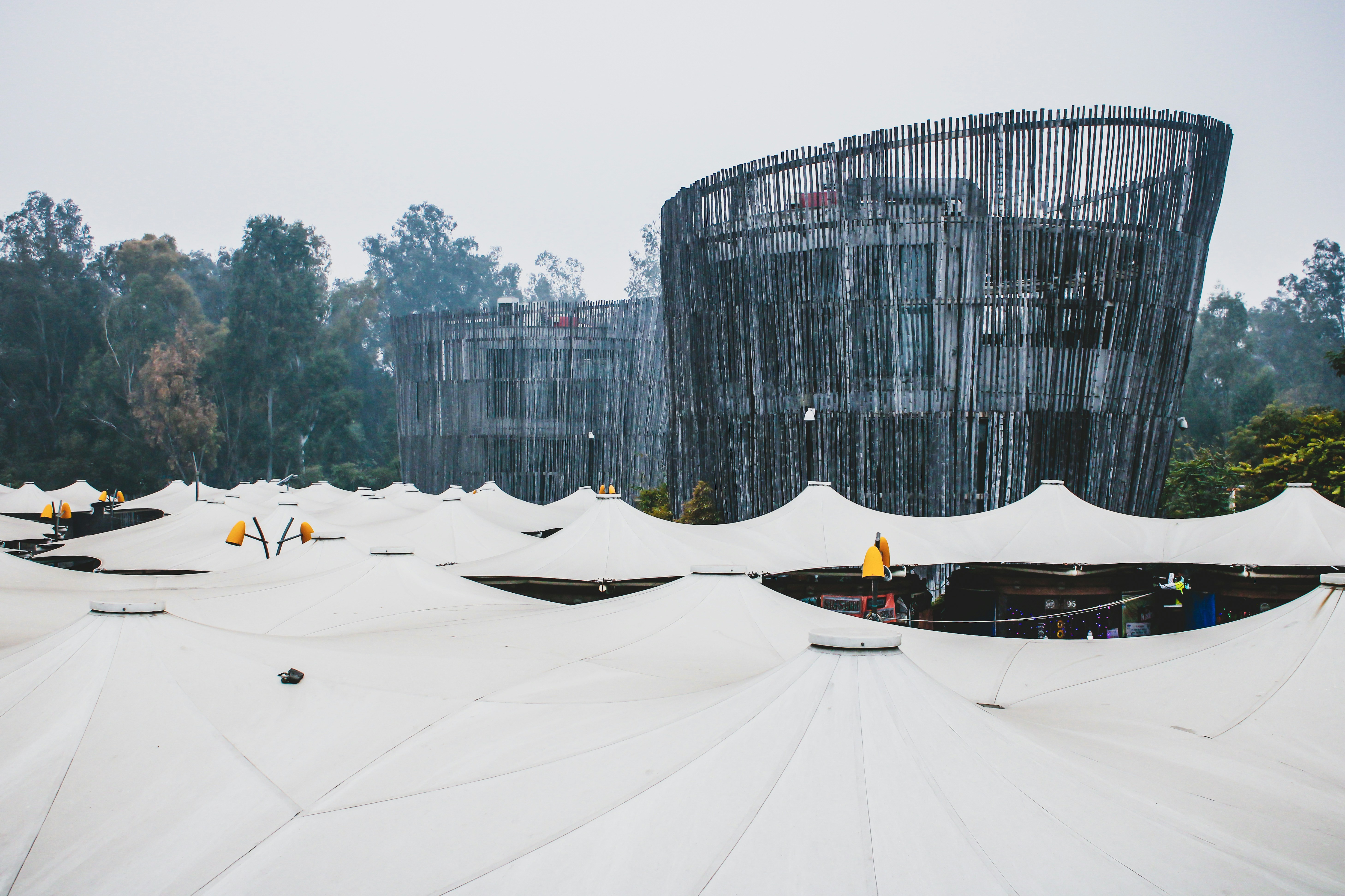 Lattice Tower Rising Over a Sea of White Canopies