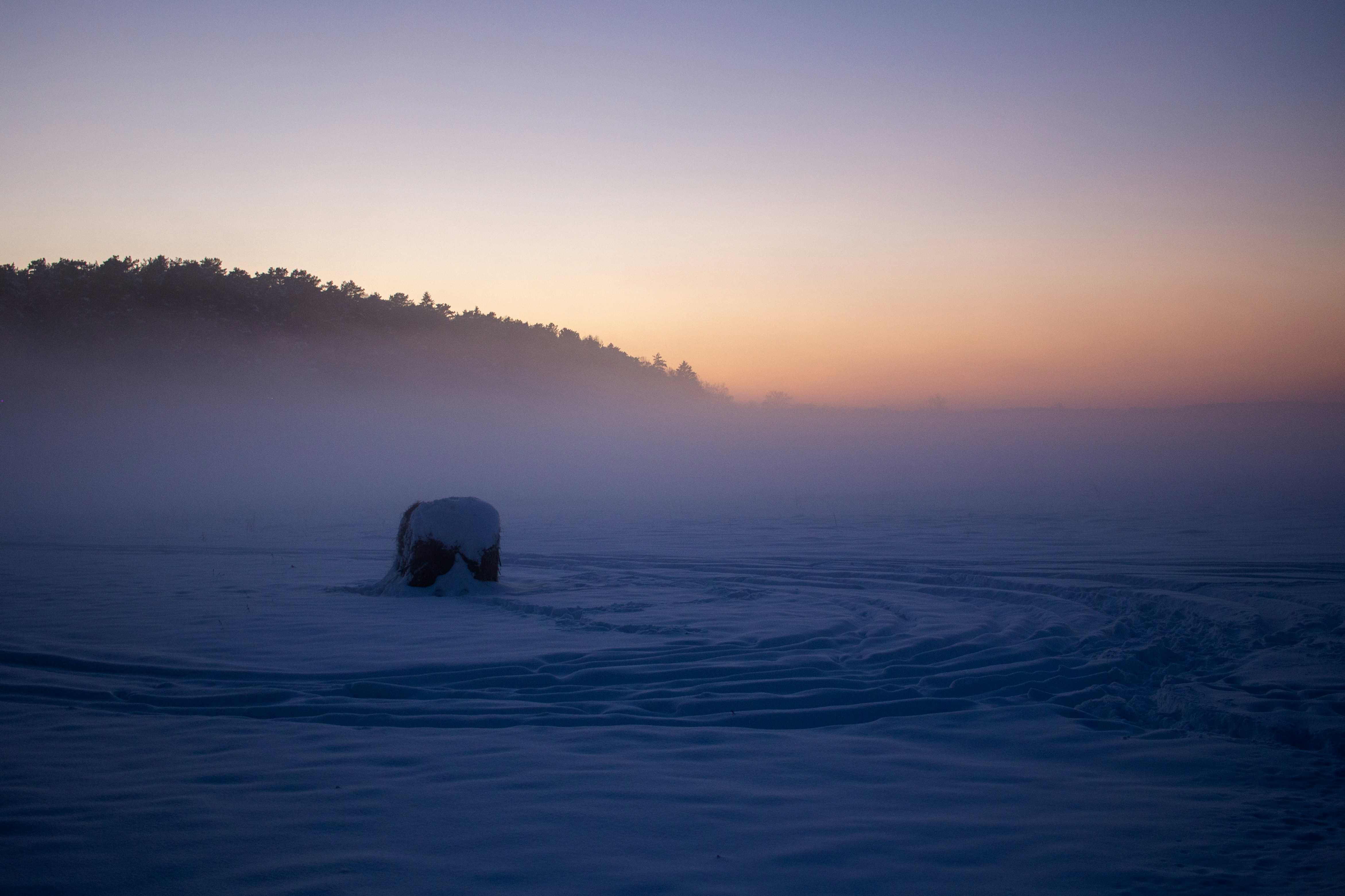 Dawn Mist over a Snowbound Expanse with a Lone Snow Block