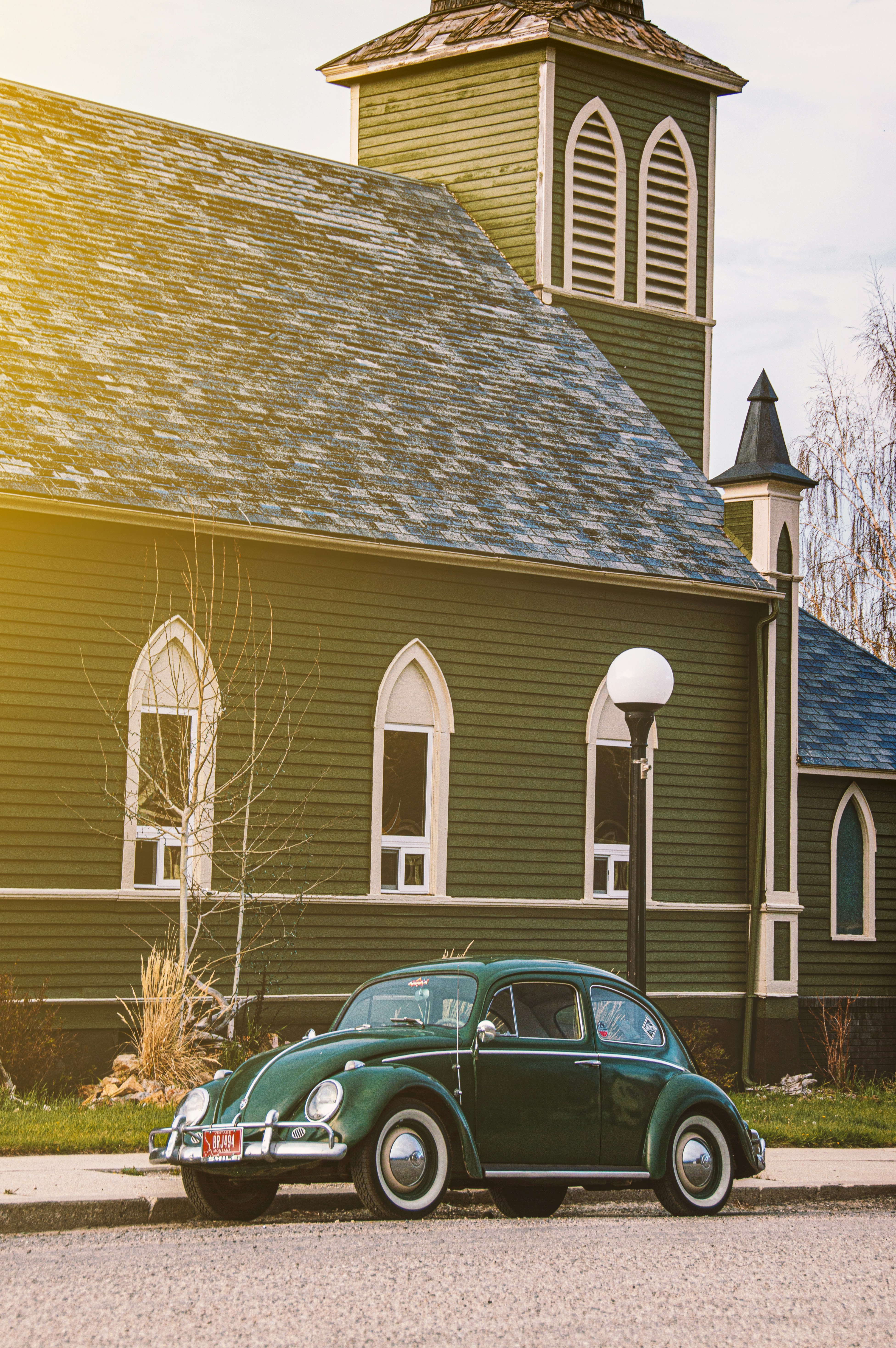 a green car parked in front of a church