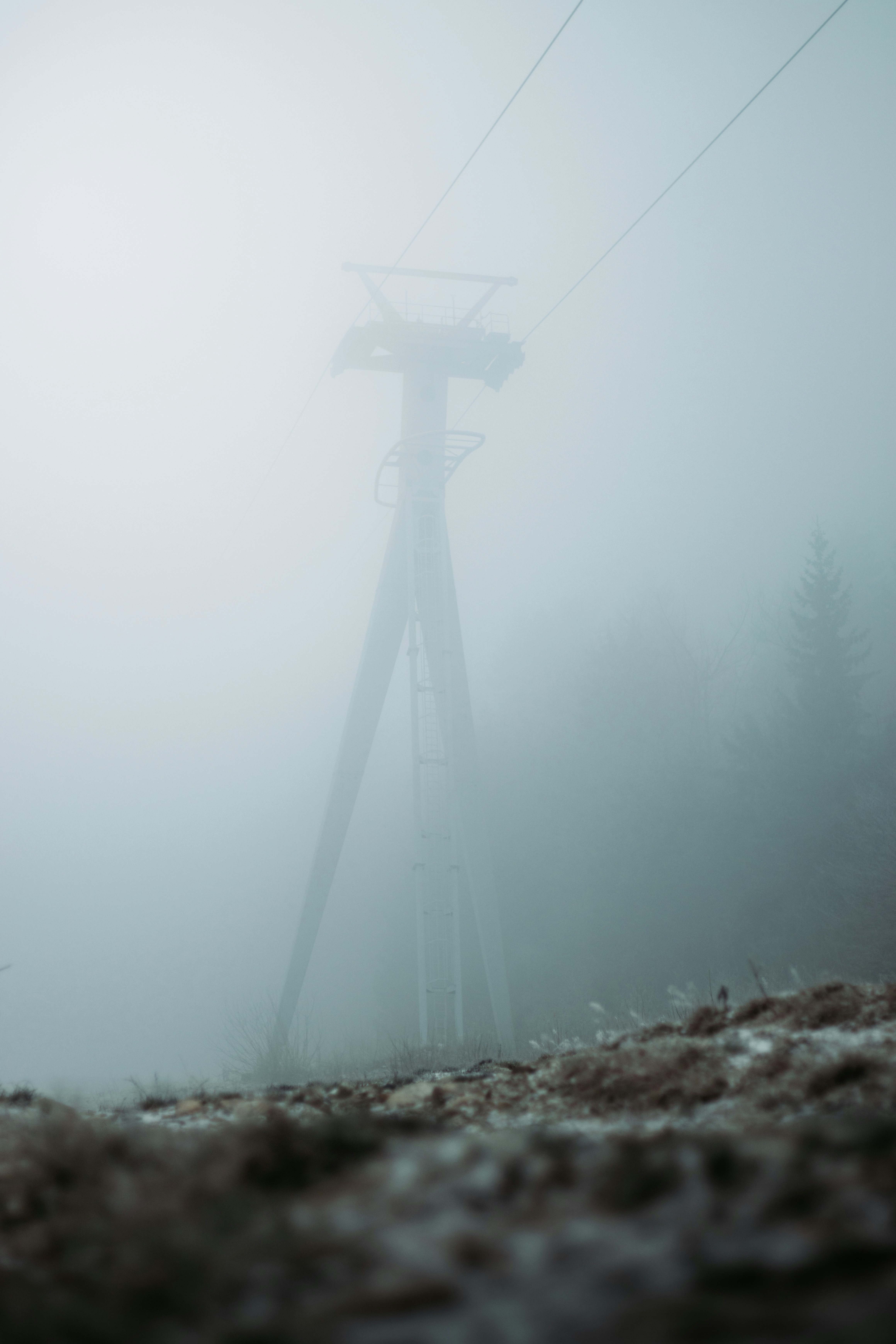Veiled Summit: A Fog-Quiet Ski Lift Tower Emerges from Mist