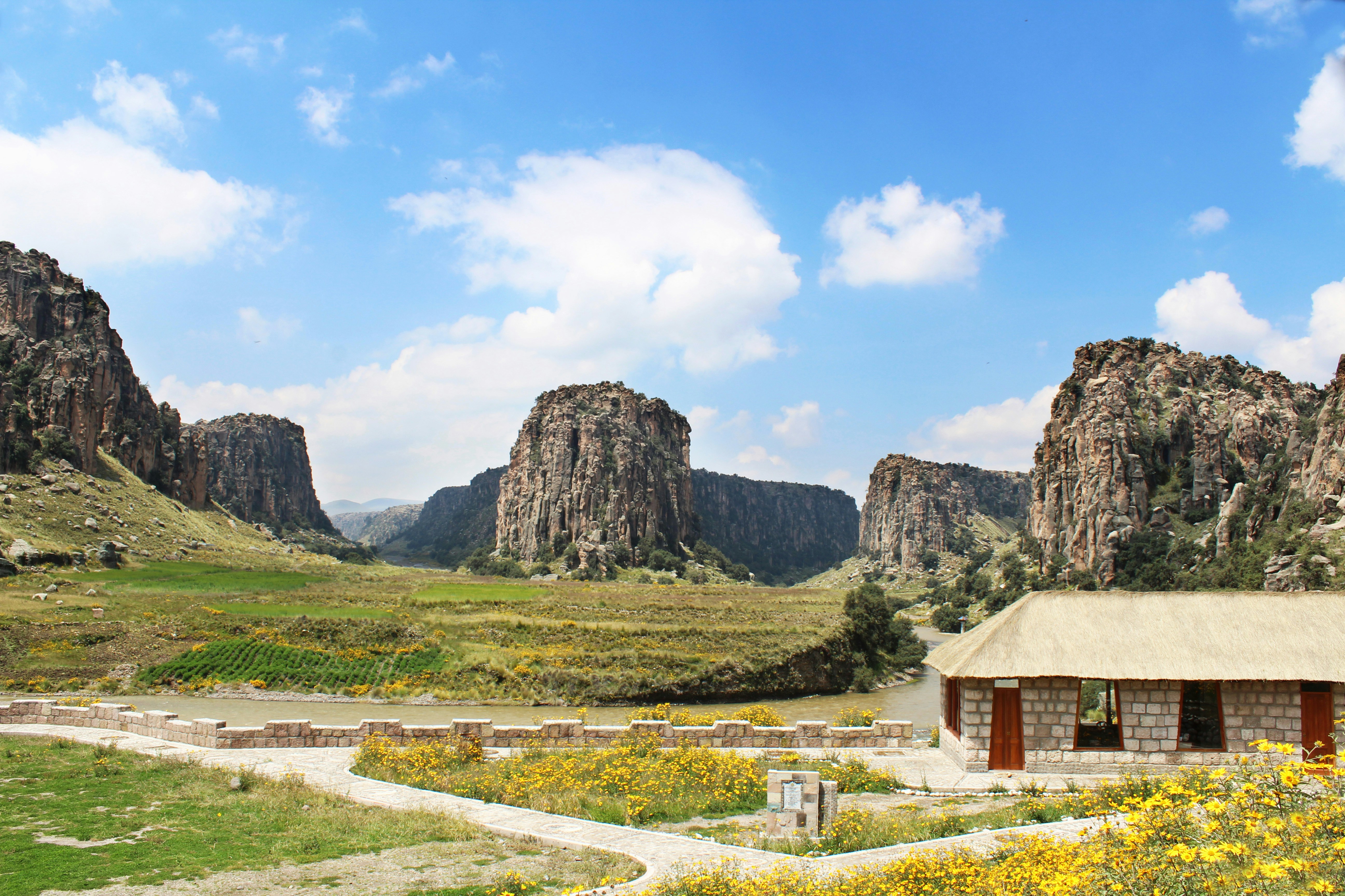 A small building in a field with mountains in the background photo ...
